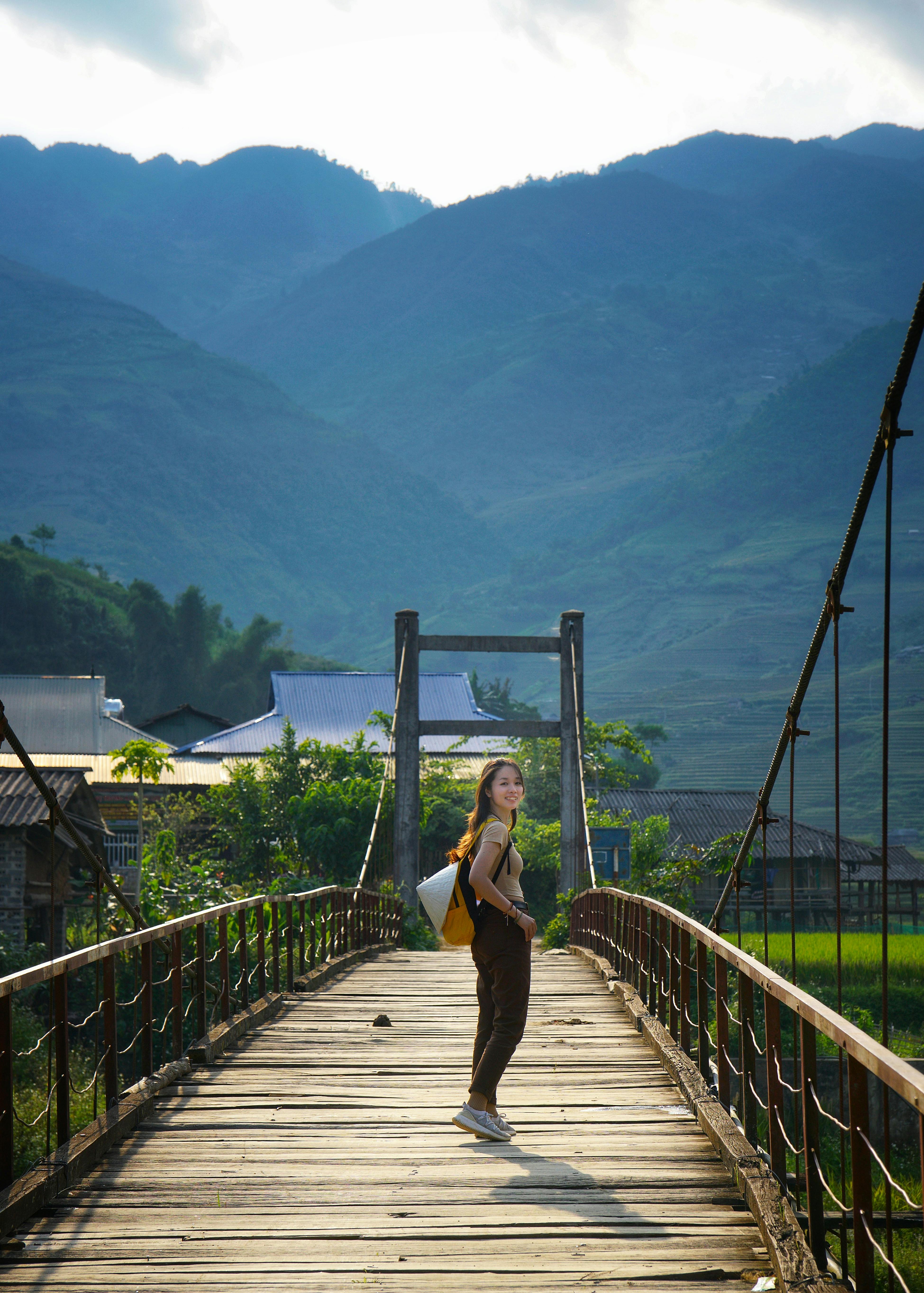 A Woman with Backpack Standing on Footbridge · Free Stock Photo