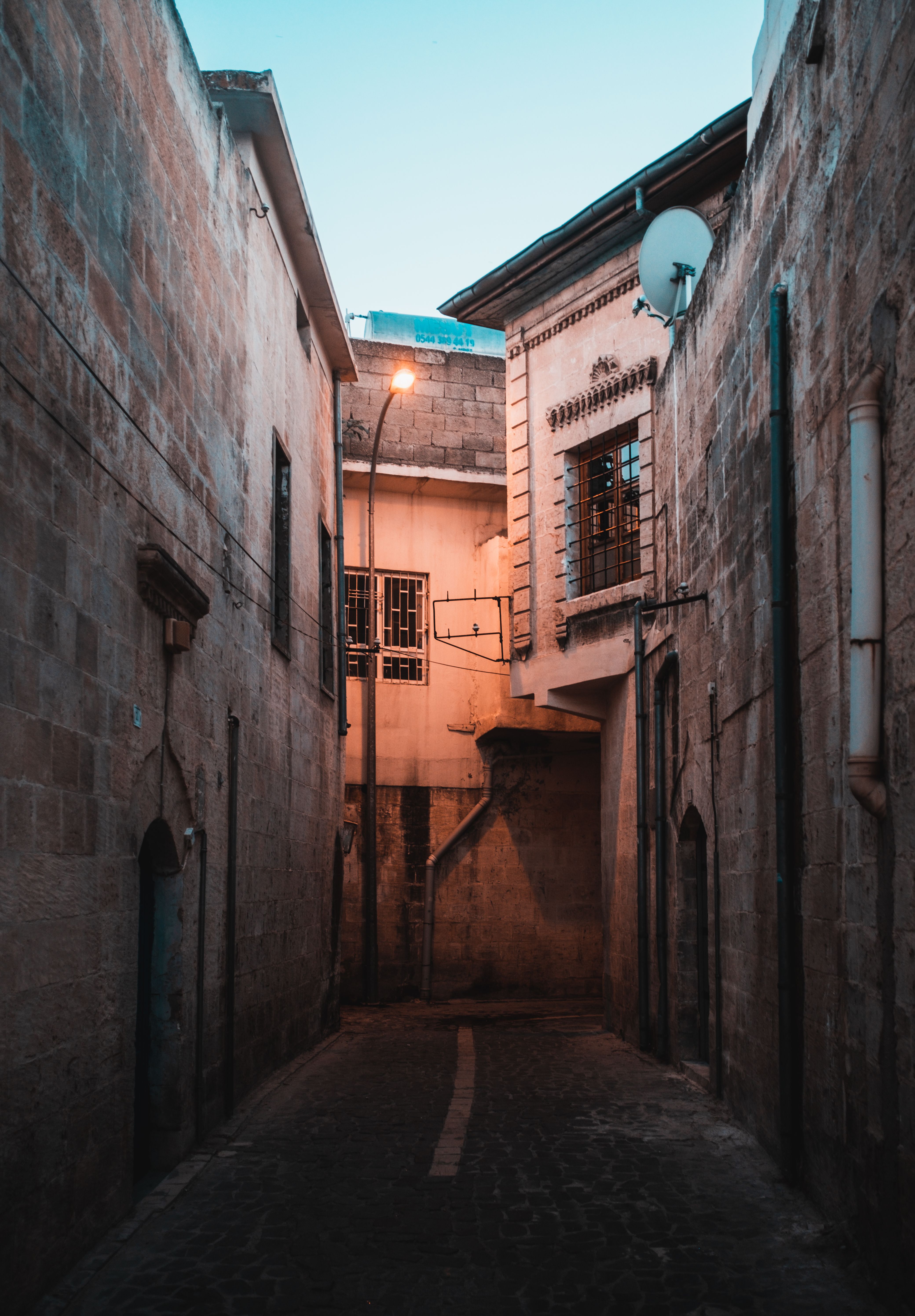 Stone Paved Alley in between Brown Concrete Buildings · Free Stock Photo