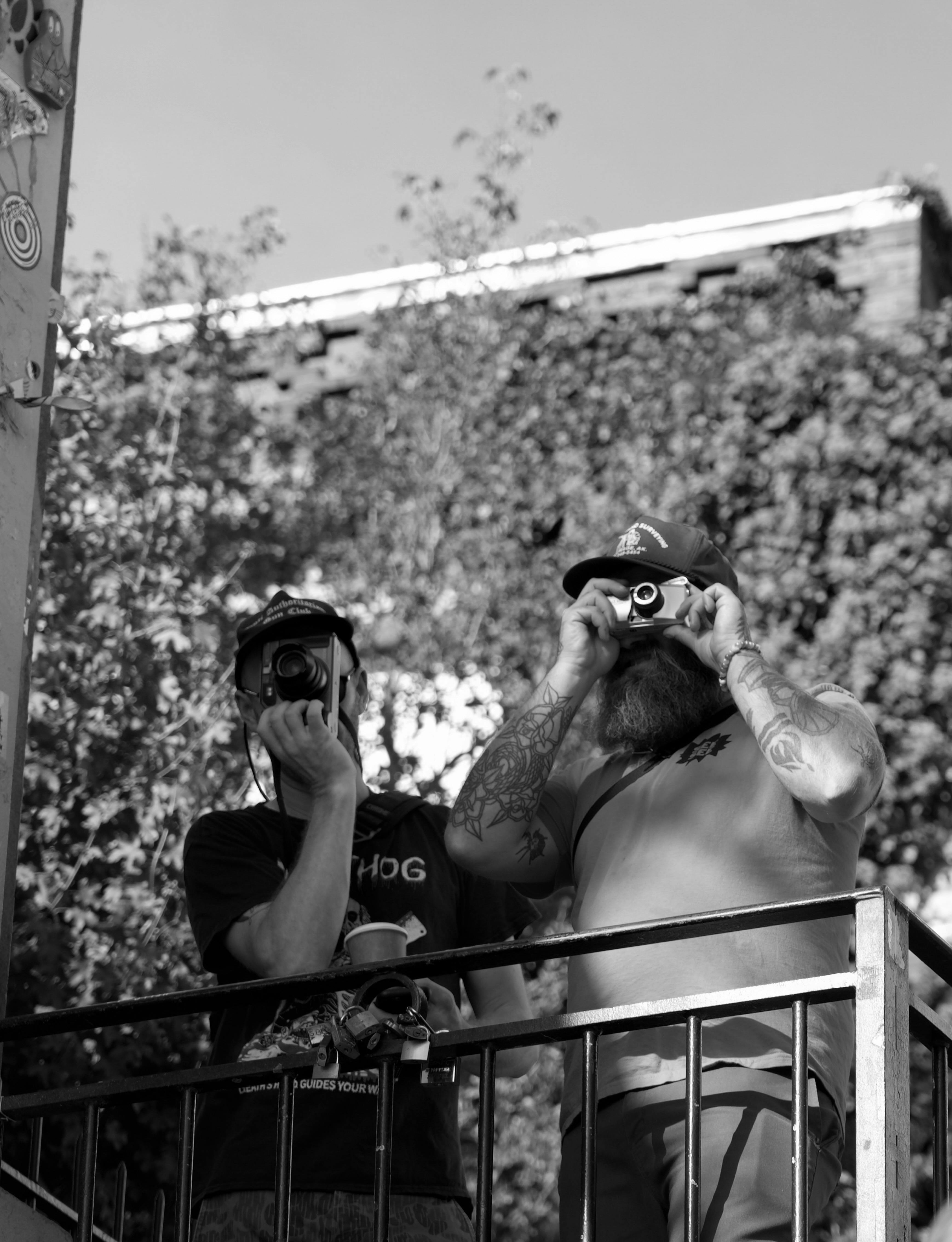 Grayscale Photo of Man in Black Hat and Coat Holding Camera · Free ...