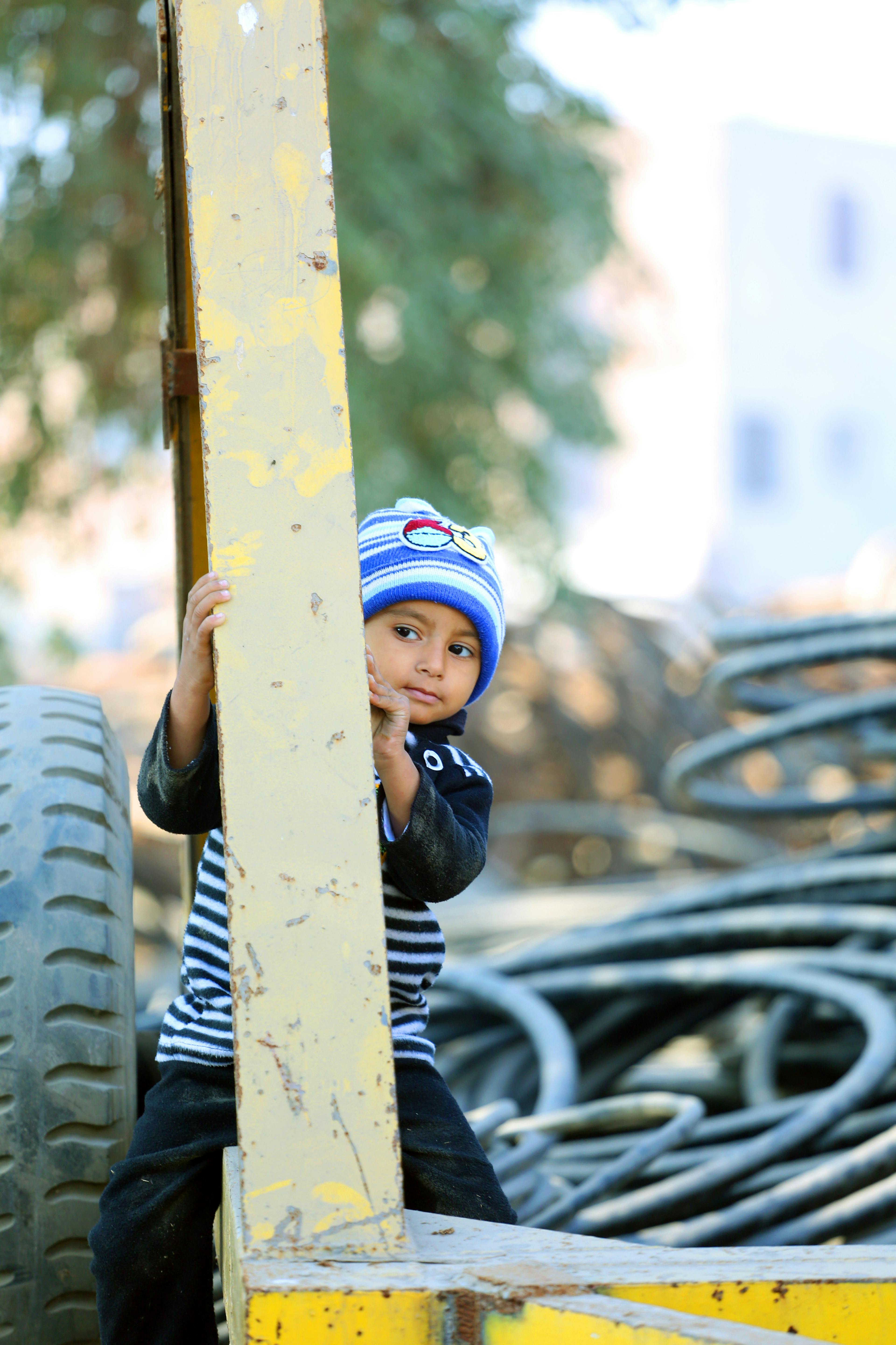 Boy Standing near Post · Free Stock Photo