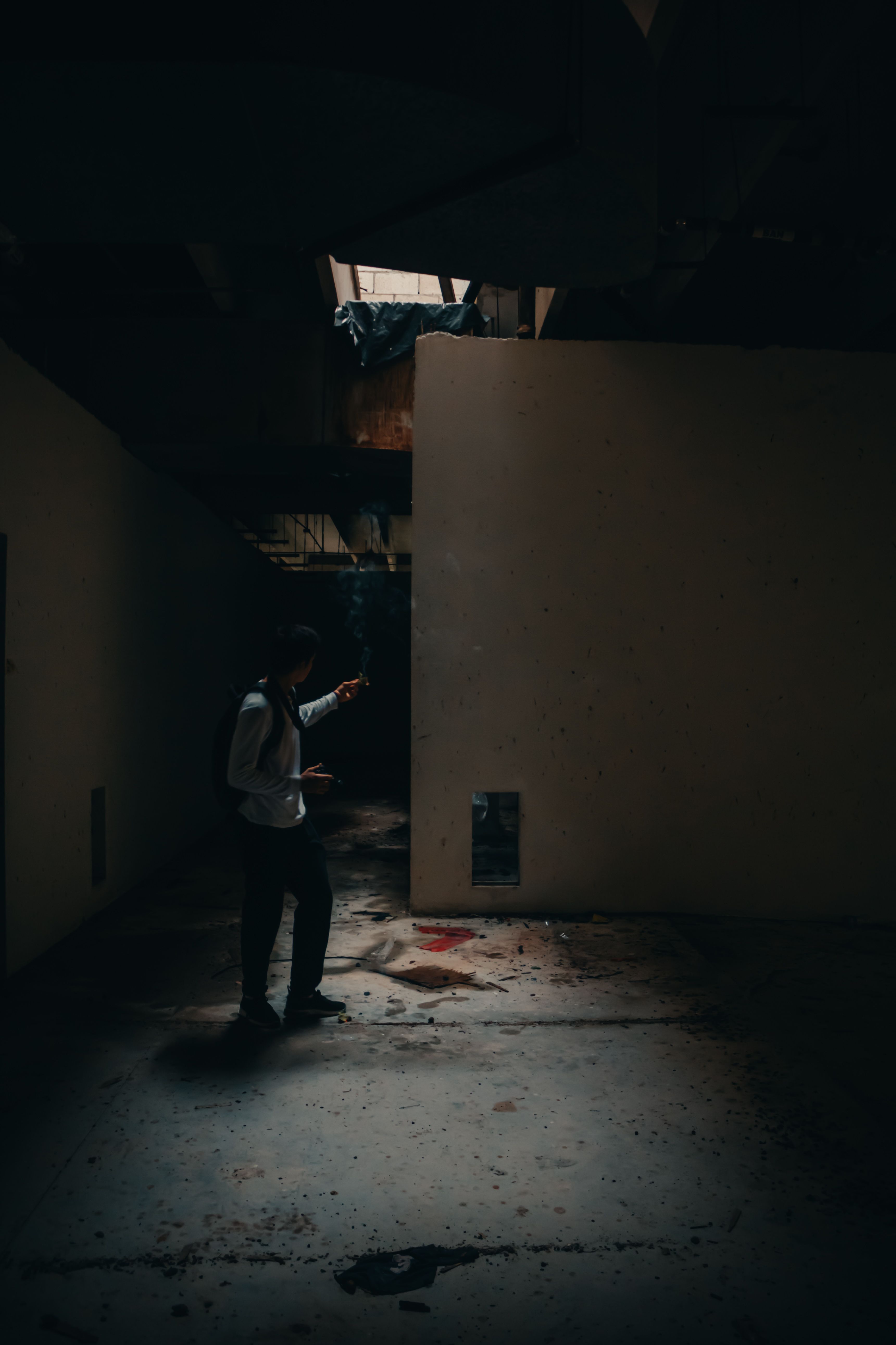 Man Smoking Cigarette in Dreary Building · Free Stock Photo
