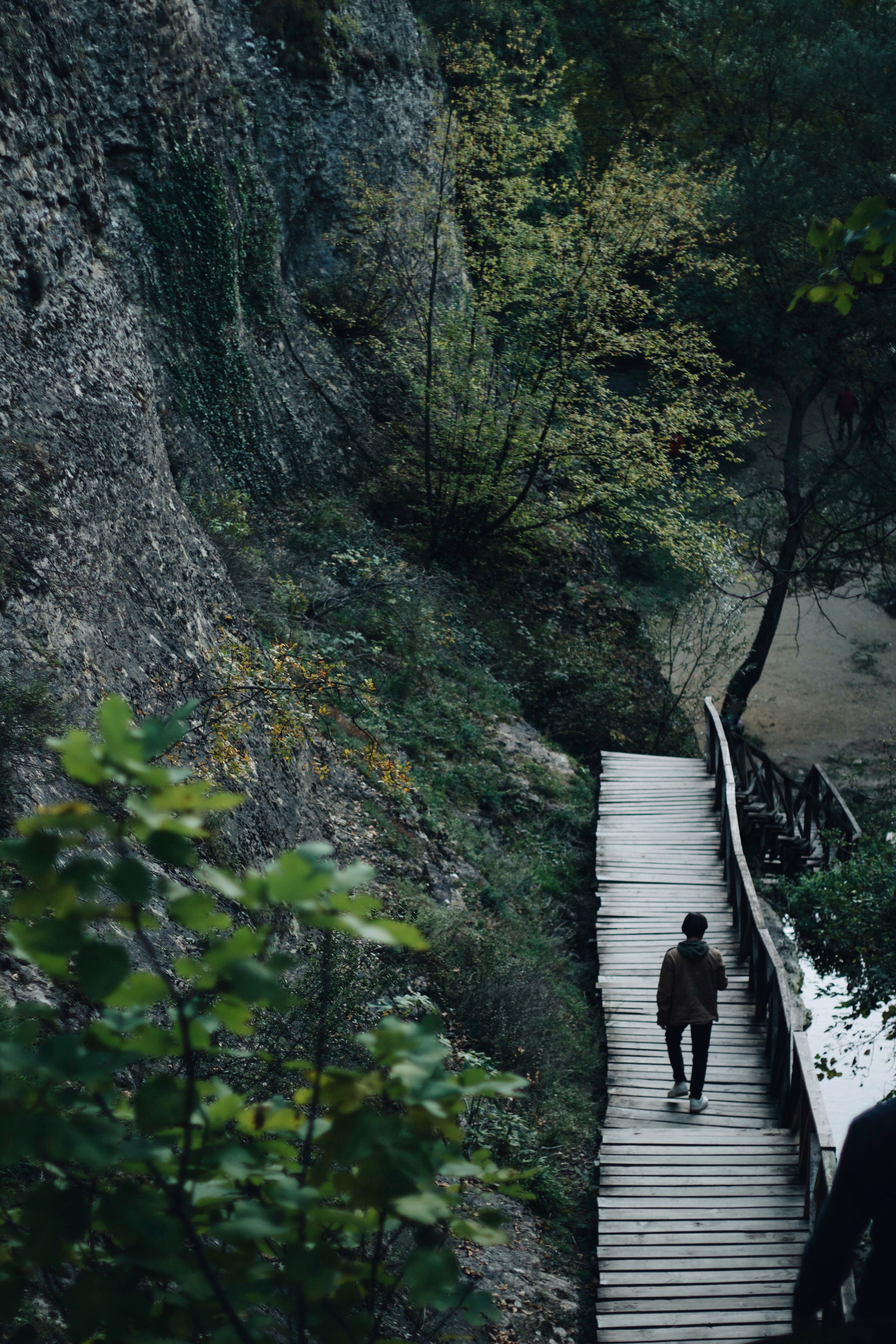 Man Walking on a Promenade under a Cliff · Free Stock Photo