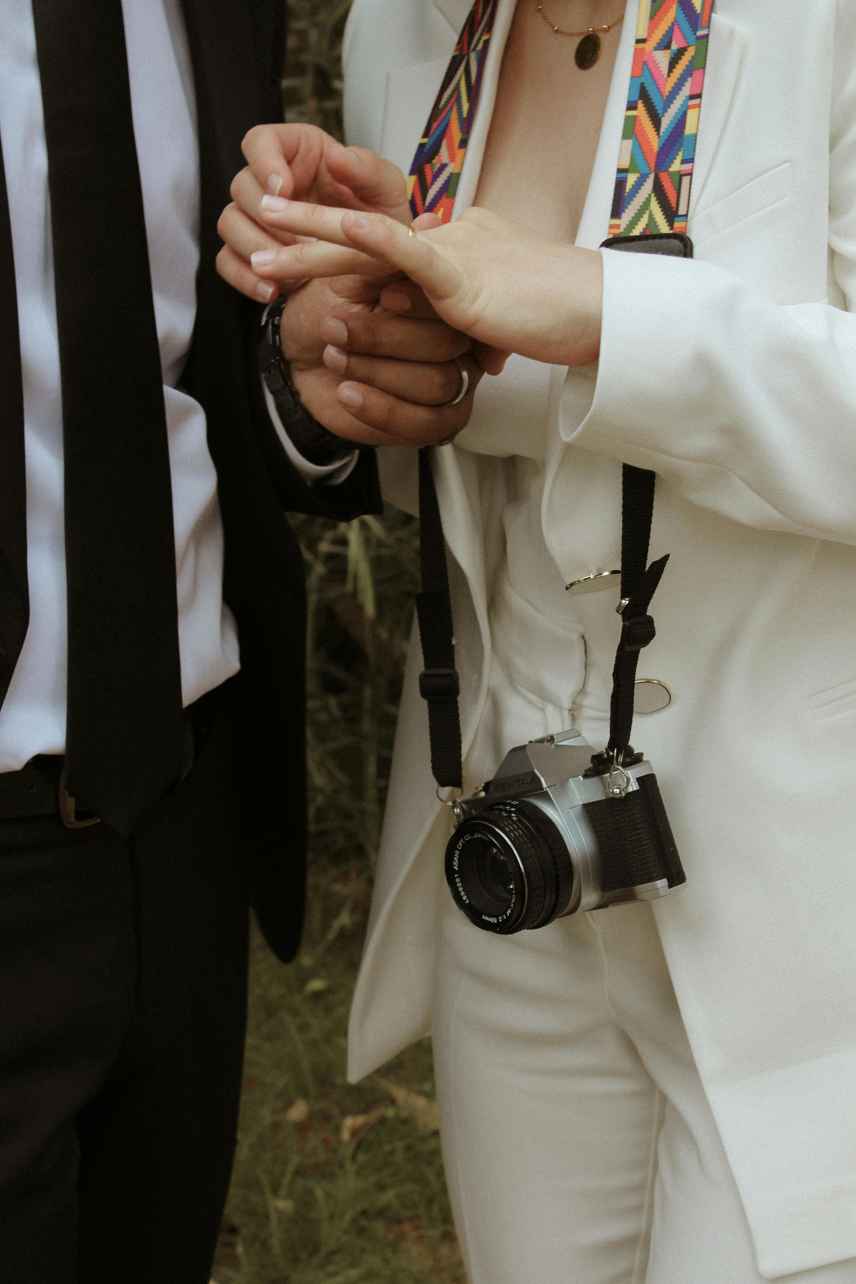 Woman With Camera on Strap Holding Hands With a Man · Free Stock Photo