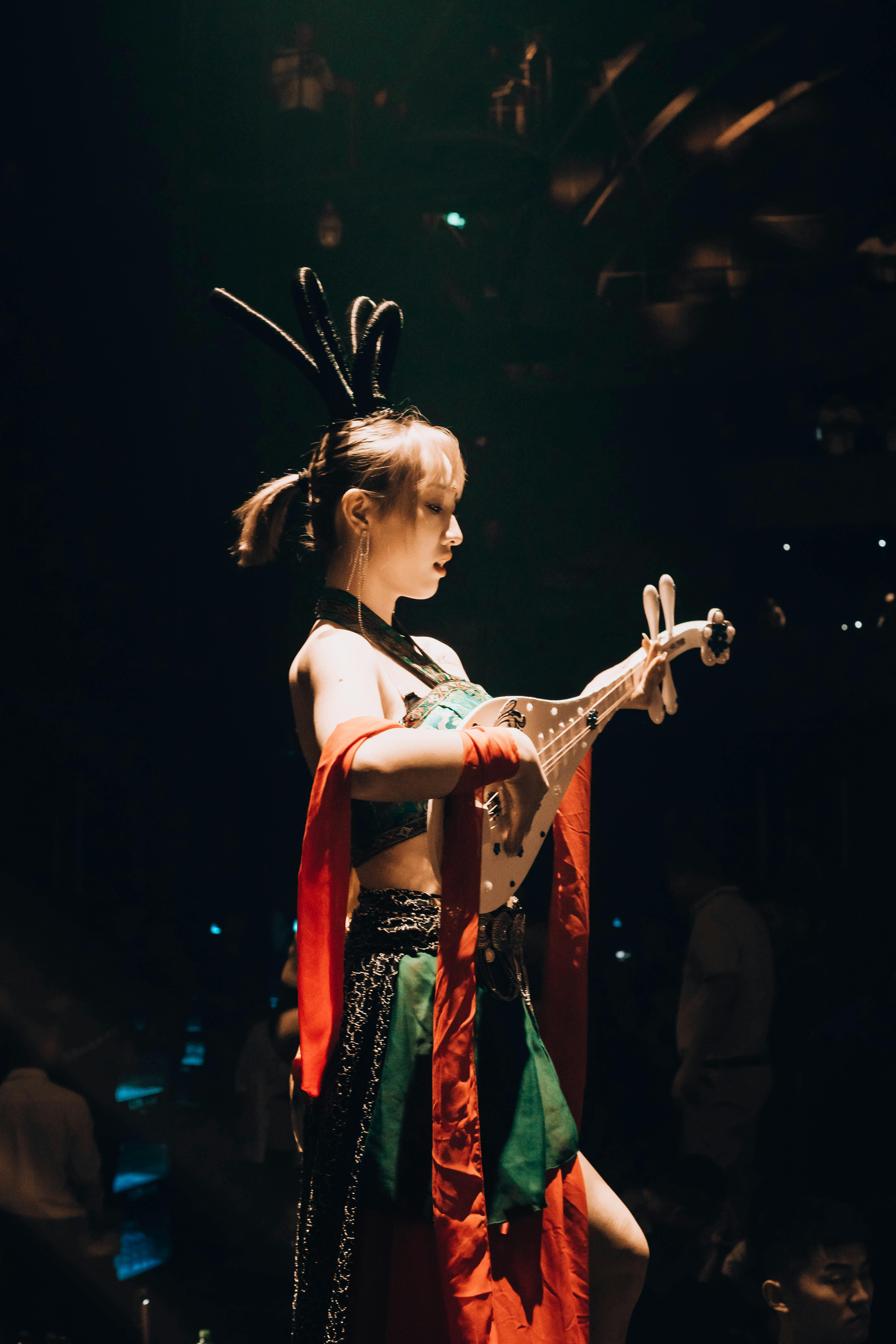 Artist in Traditional Clothing Playing on Stage · Free Stock Photo