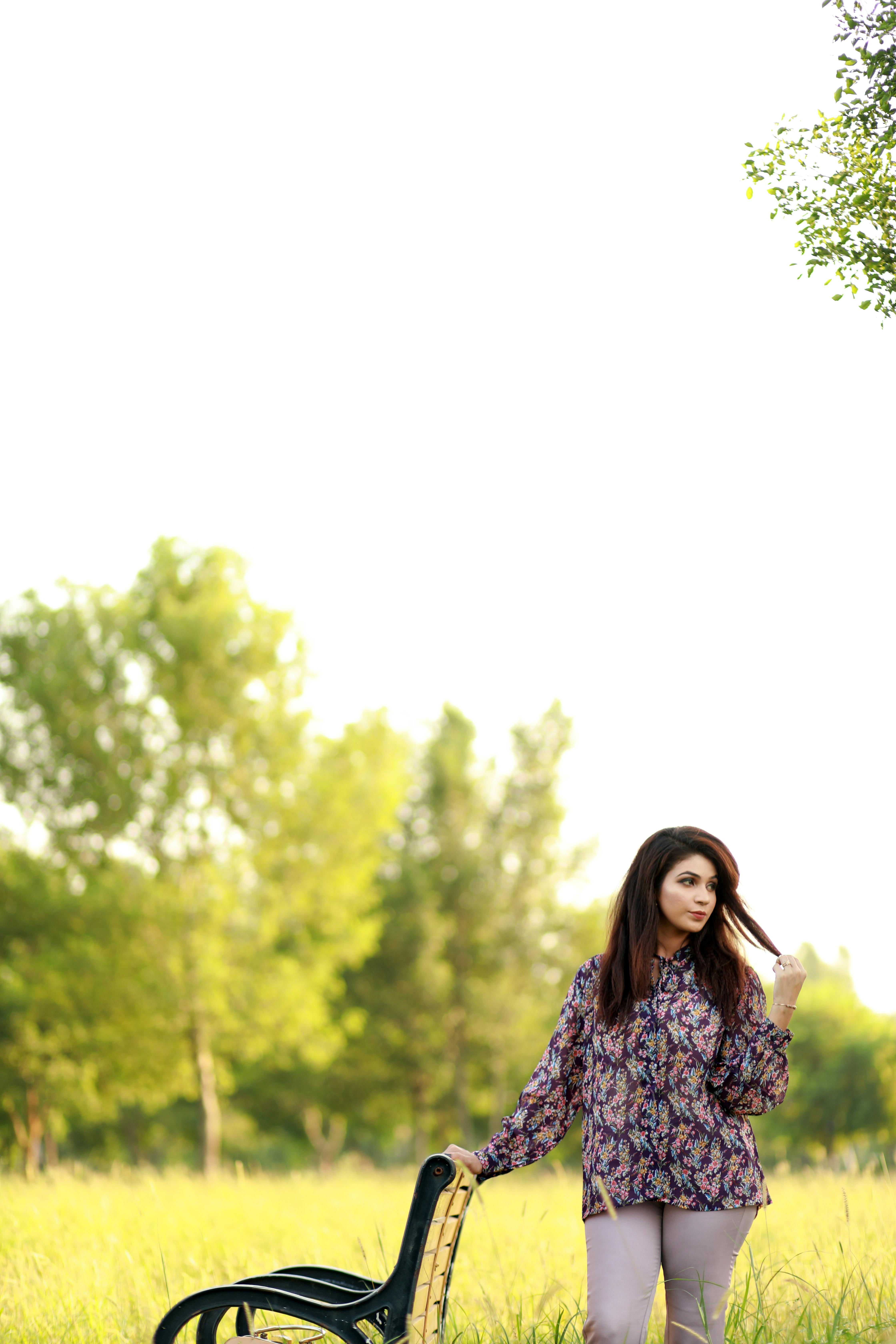 Woman Standing on Grass Field Beside a Chair · Free Stock Photo