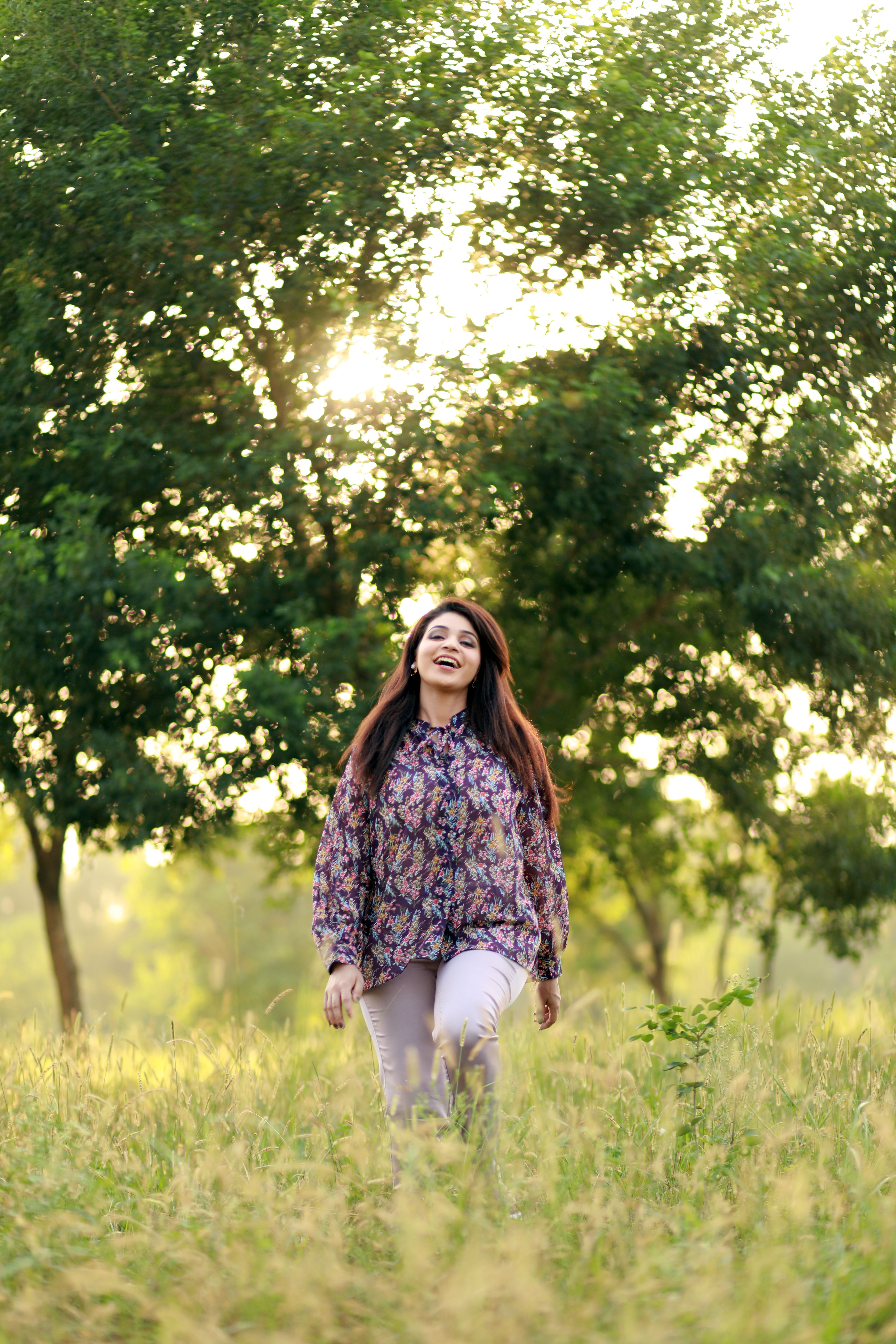 Woman Walking on Grass Field near Green Trees · Free Stock Photo