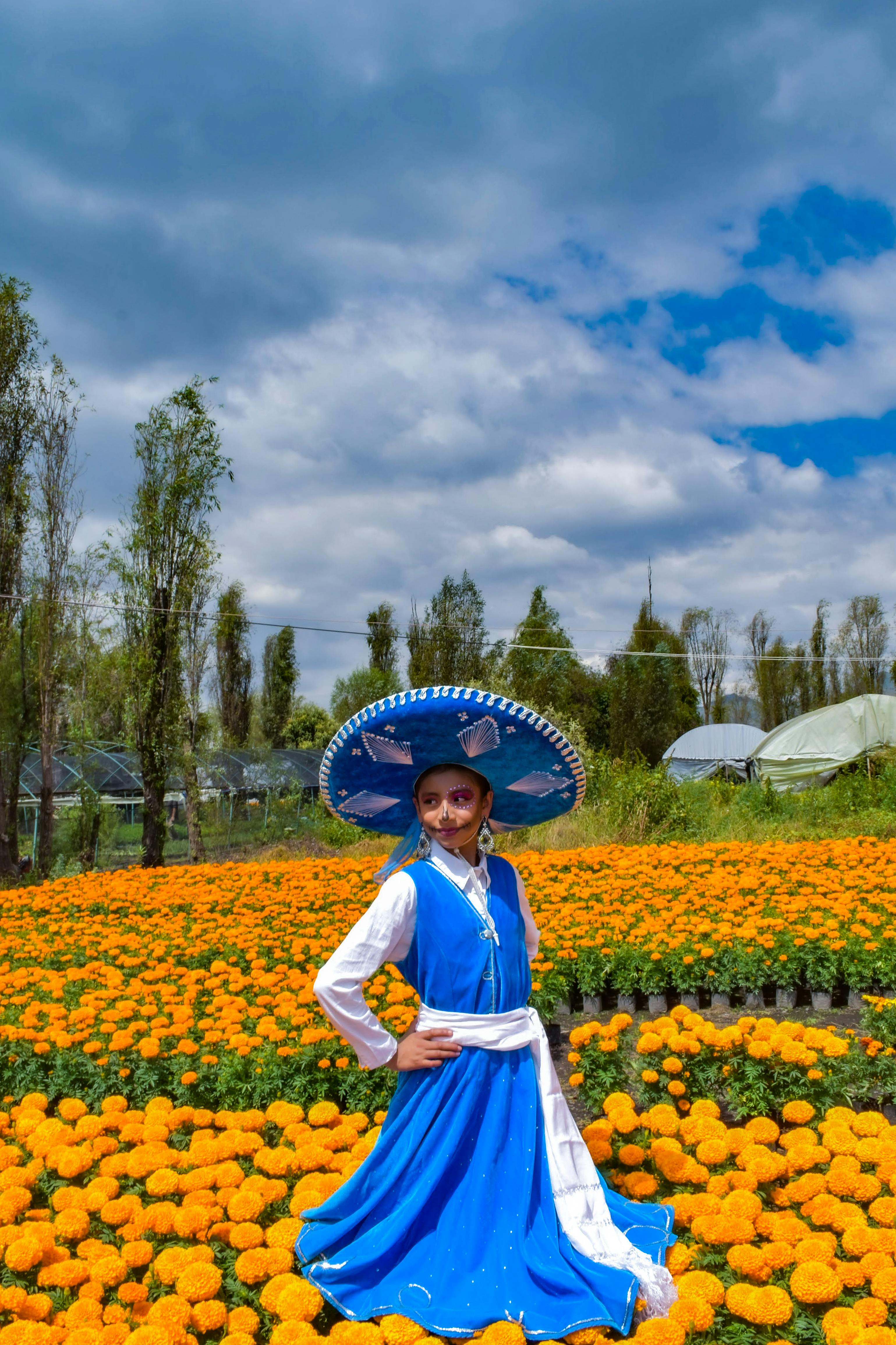 Woman in Blue Dress and Sombrero among Flowers · Free Stock Photo