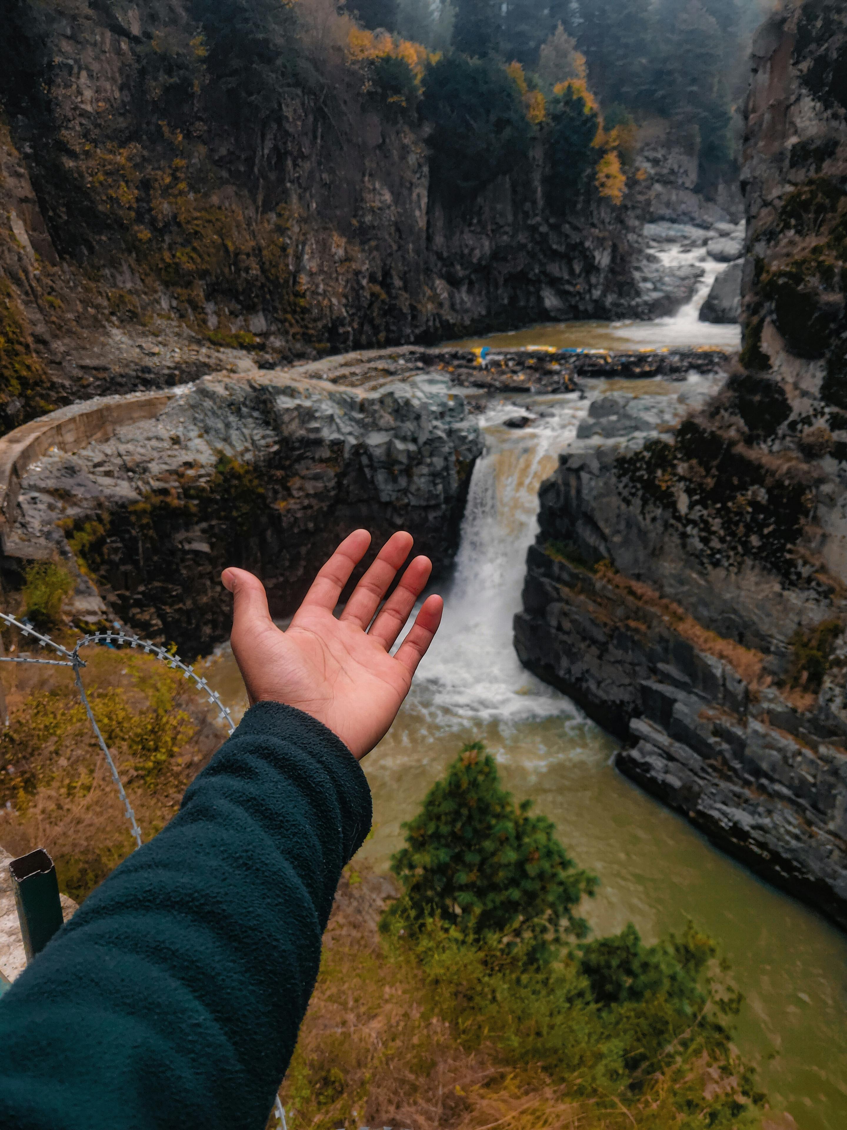 Hand and Waterfall behind · Free Stock Photo