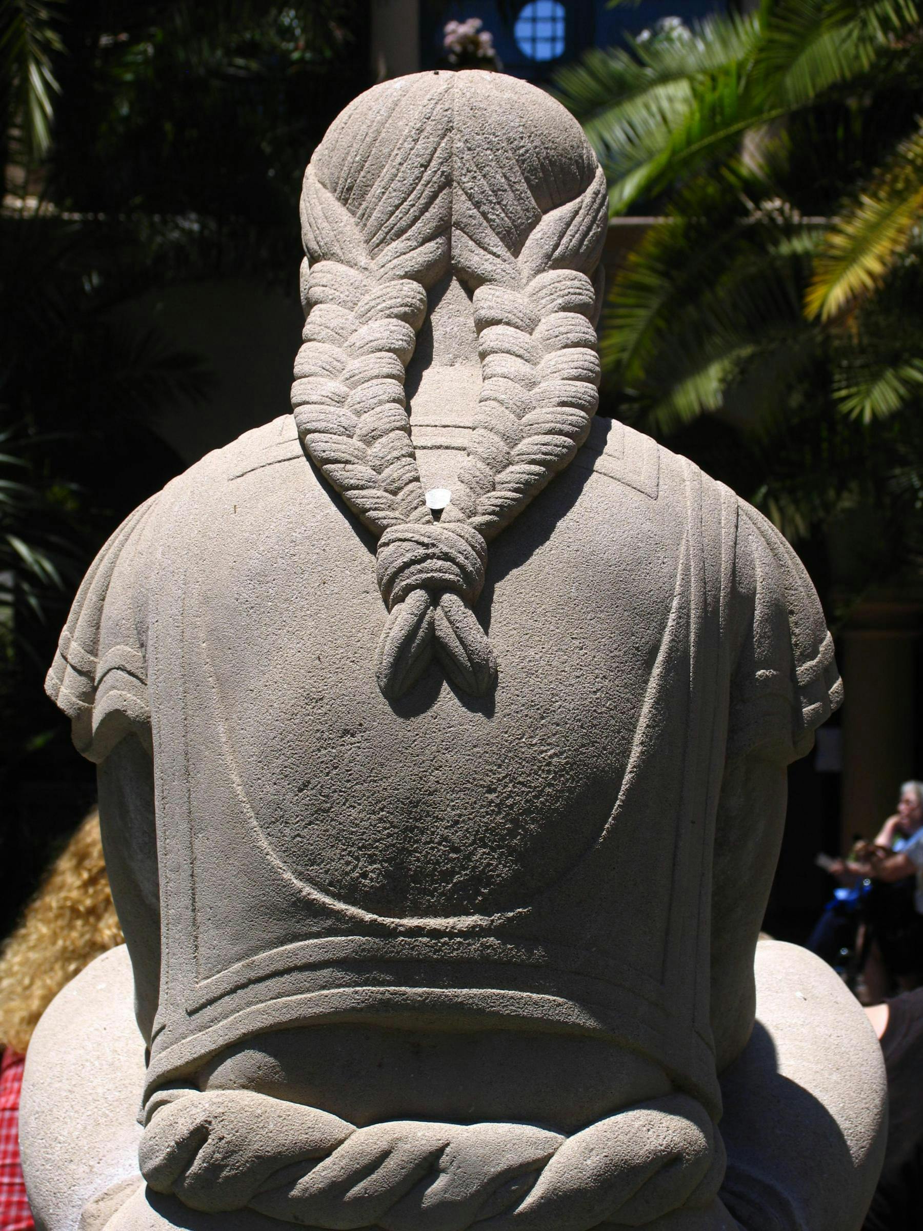 Back View of a Stone Sculpture of a Woman with Braids · Free Stock Photo