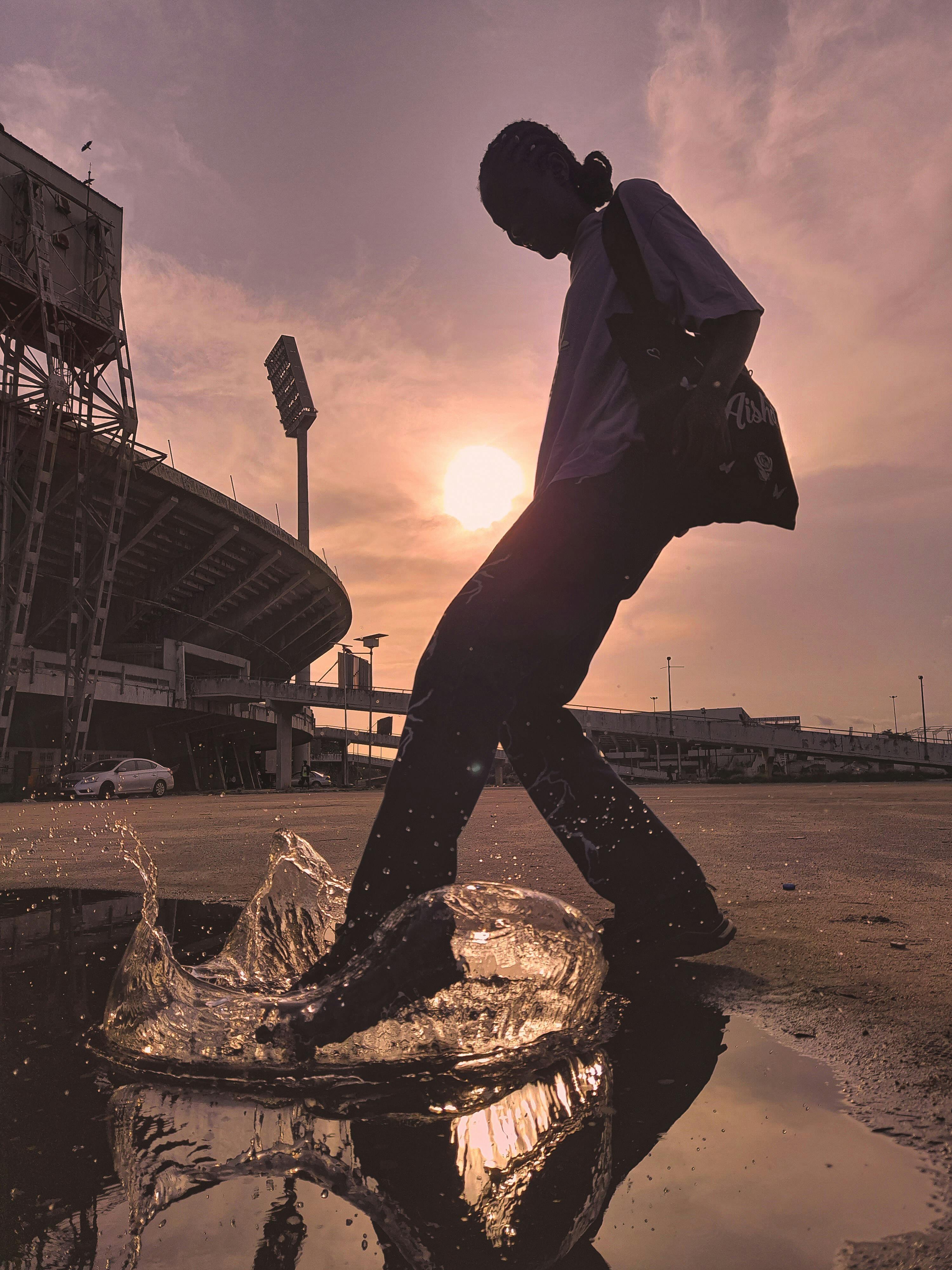 Silhouette of a Person Stepping on the Wet Ground · Free Stock Photo
