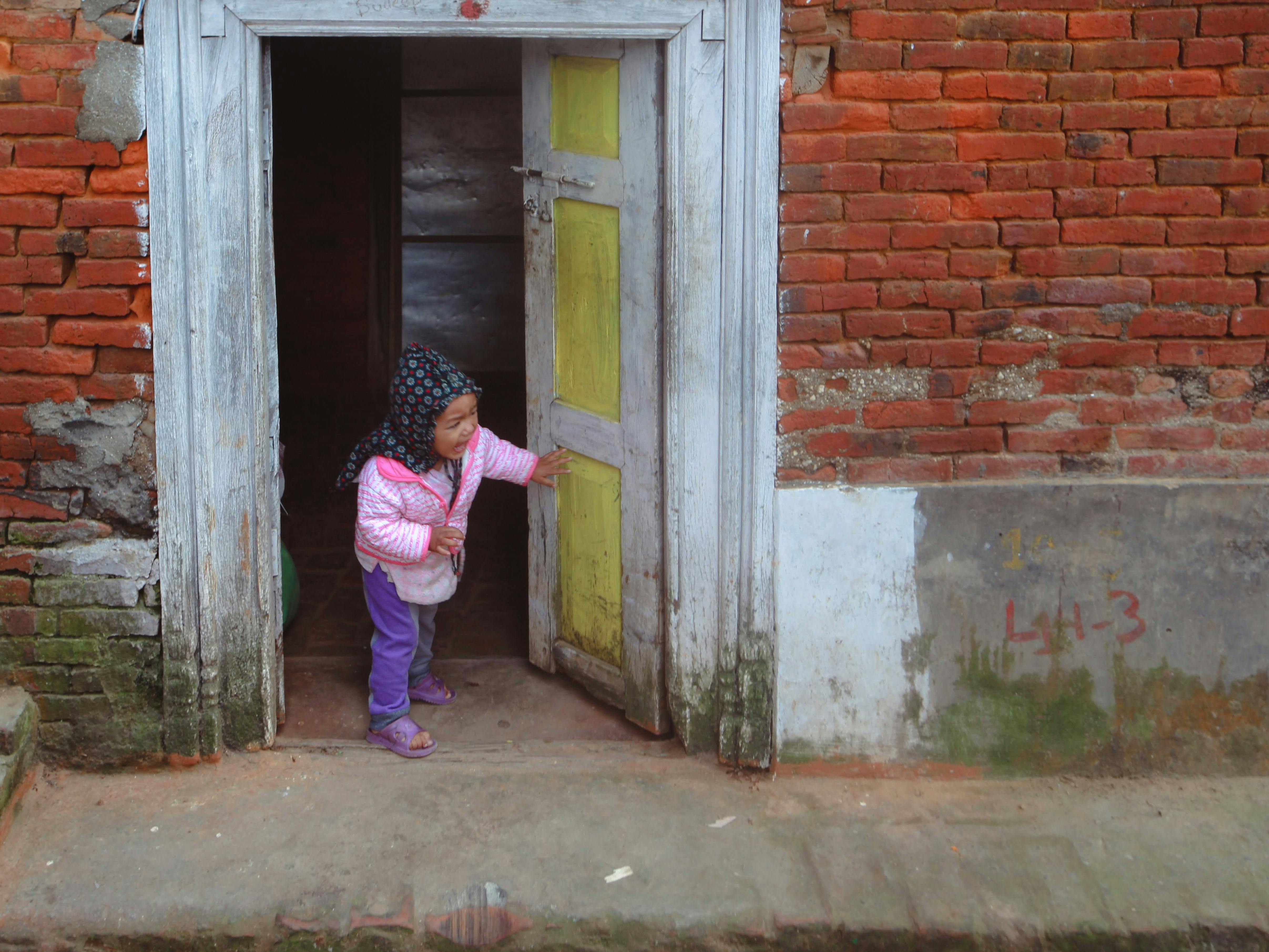 Crying Child Standing on a Doorway · Free Stock Photo