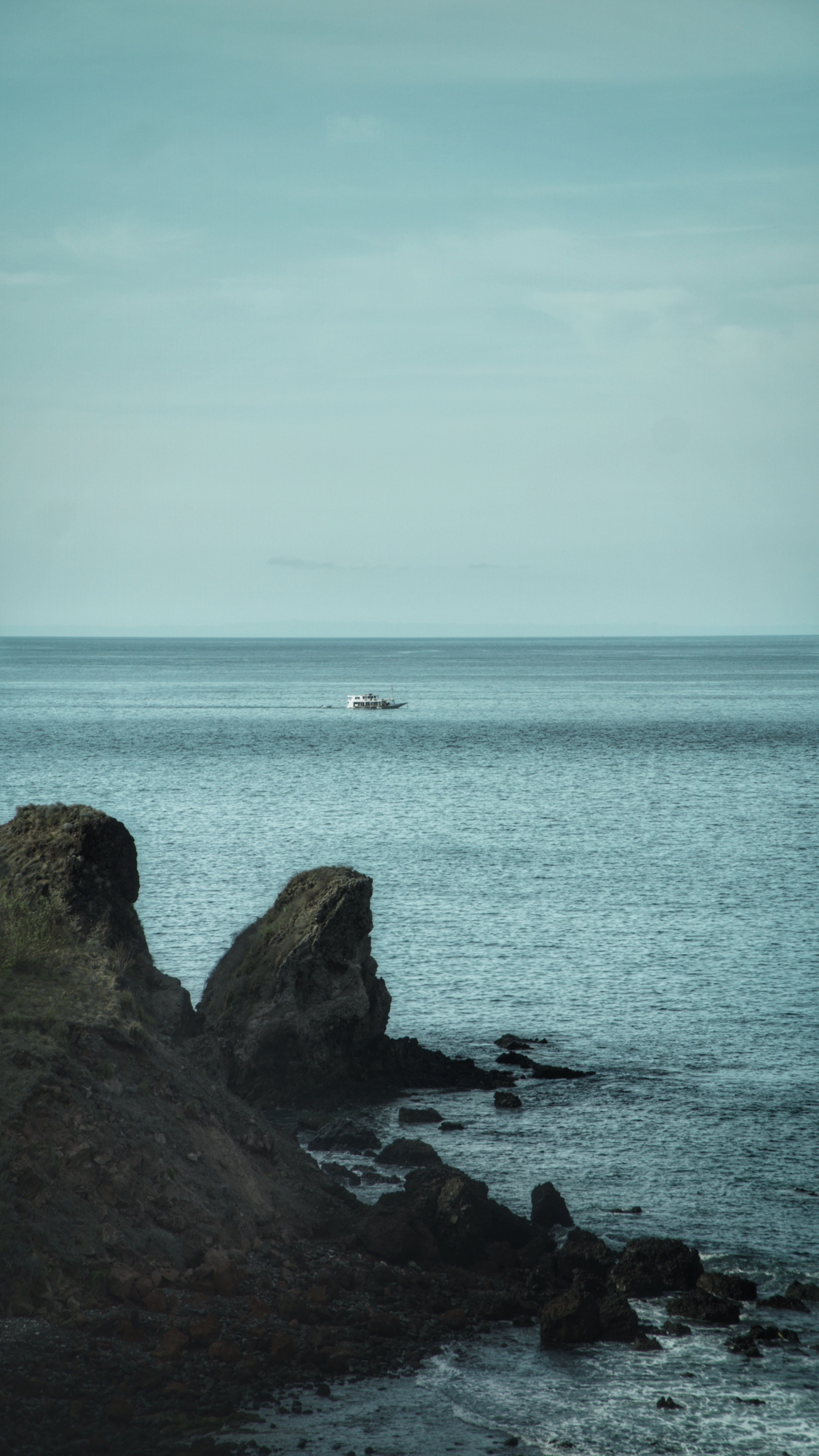 A Boat Sailing on the Sea with Rock Formations · Free Stock Photo