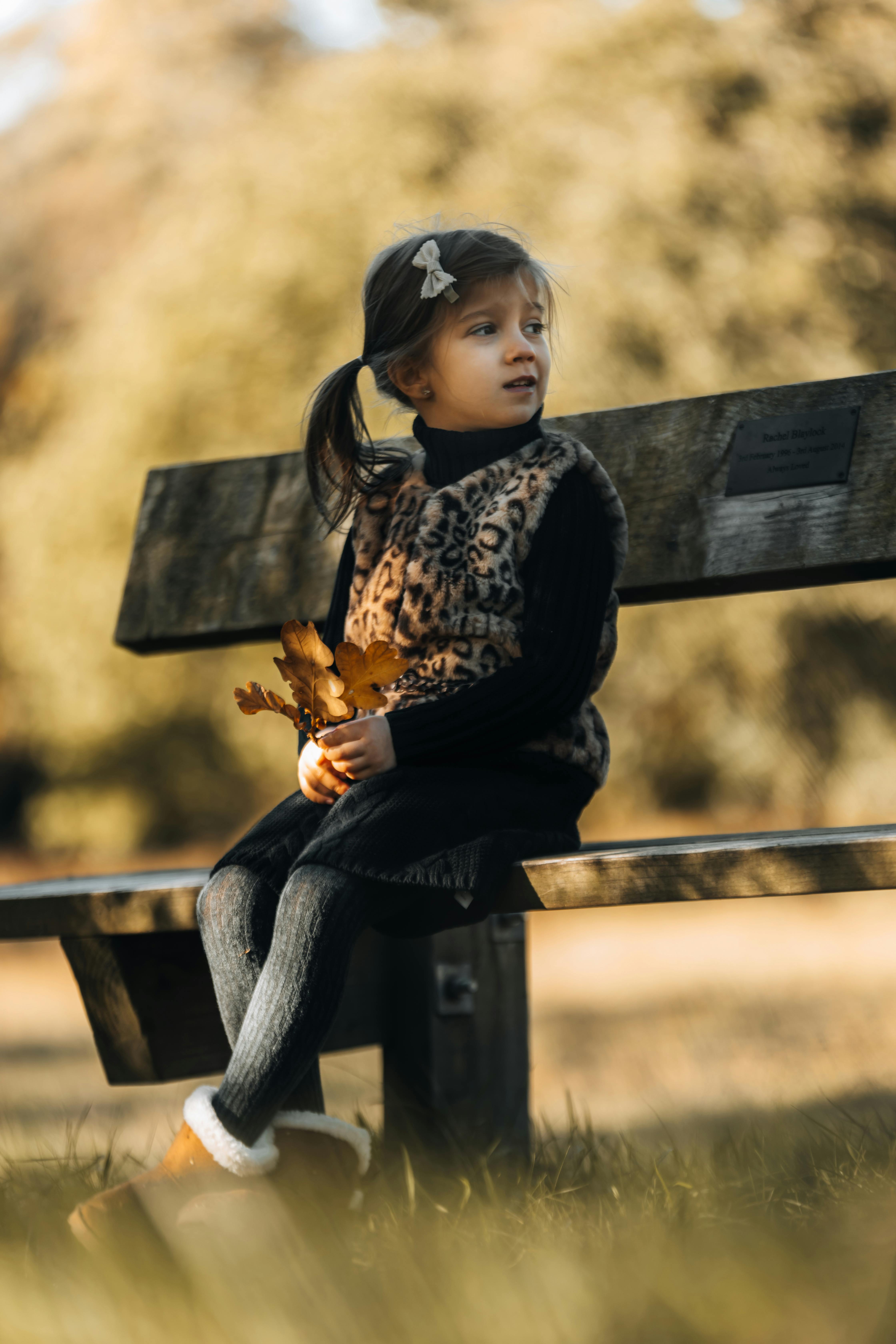 Little Girl Sitting on Wooden Bench · Free Stock Photo