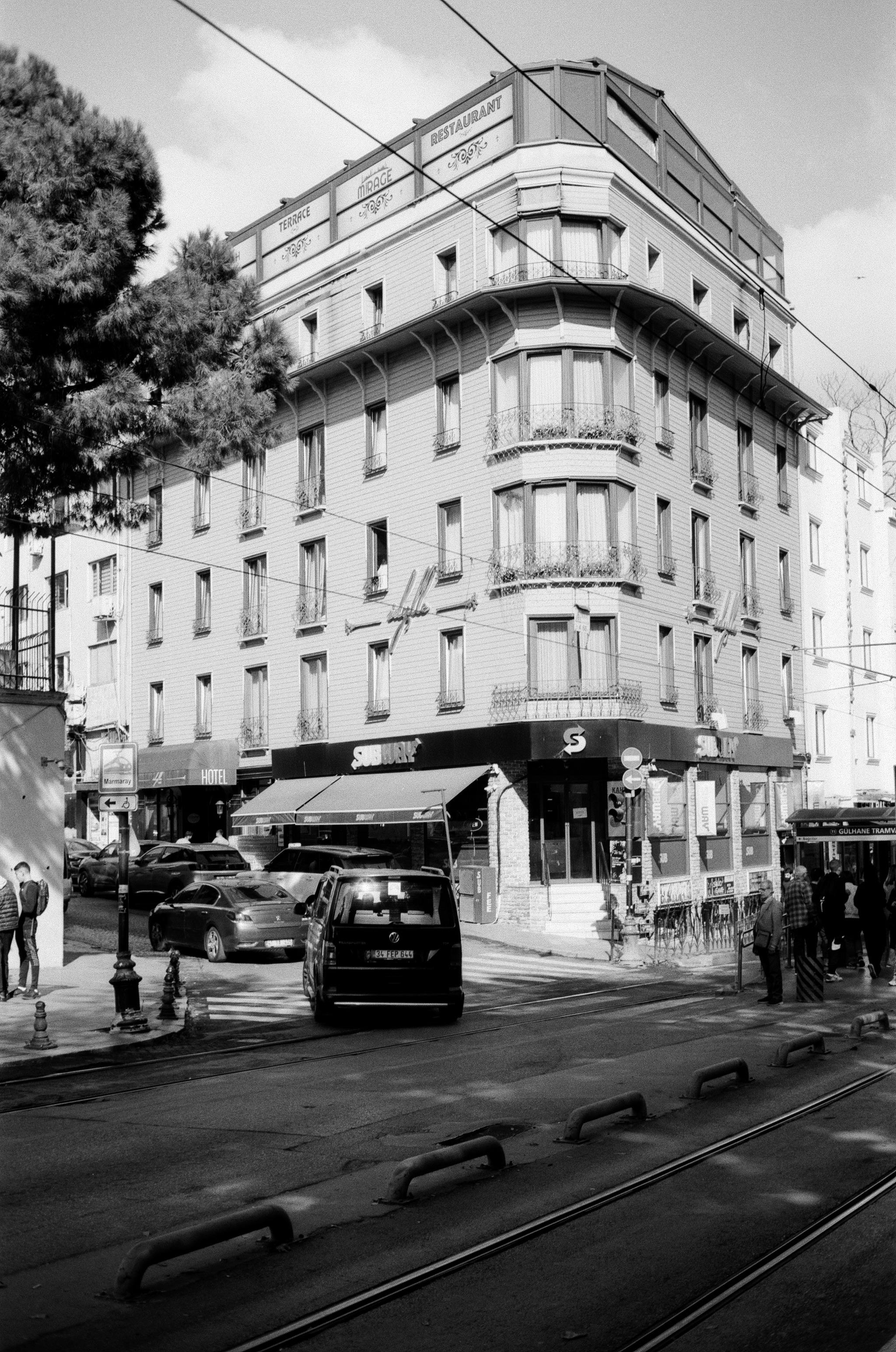 Grayscale Photo of Commercial Building on Street Corner Near Tramway ...