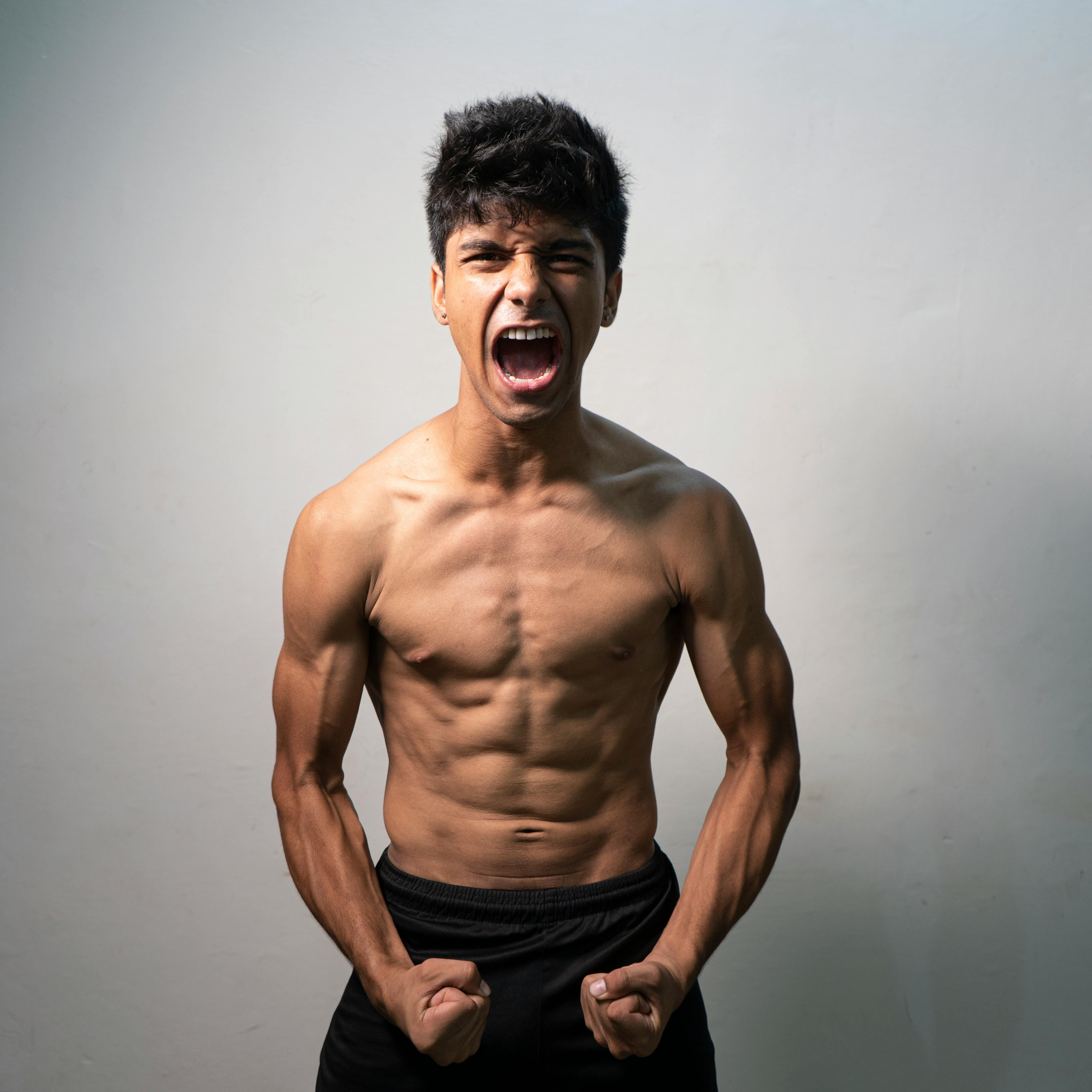 Shirtless Man Flexing His Muscles · Free Stock Photo