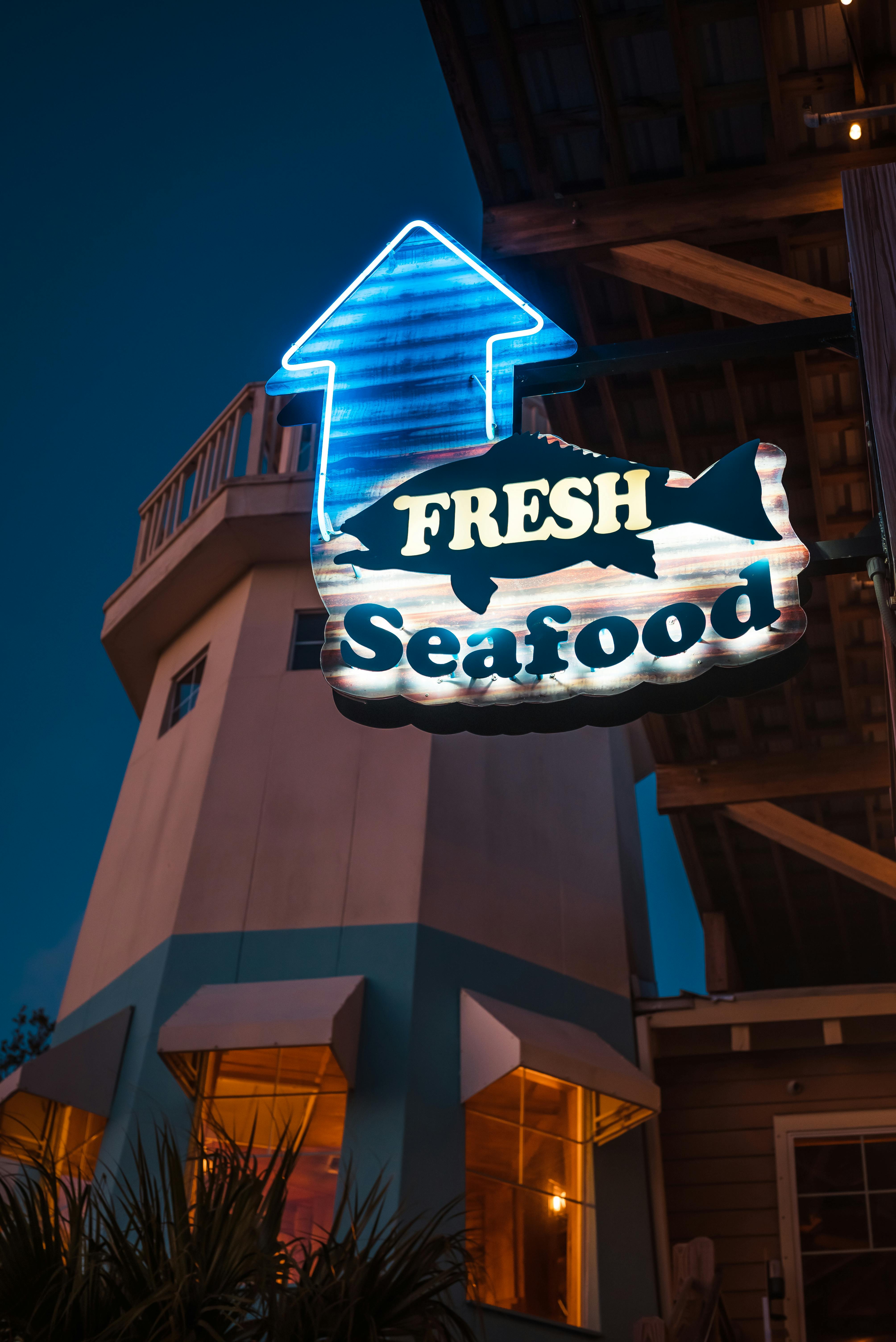 Fresh Seafood Signage Beside a Tower · Free Stock Photo