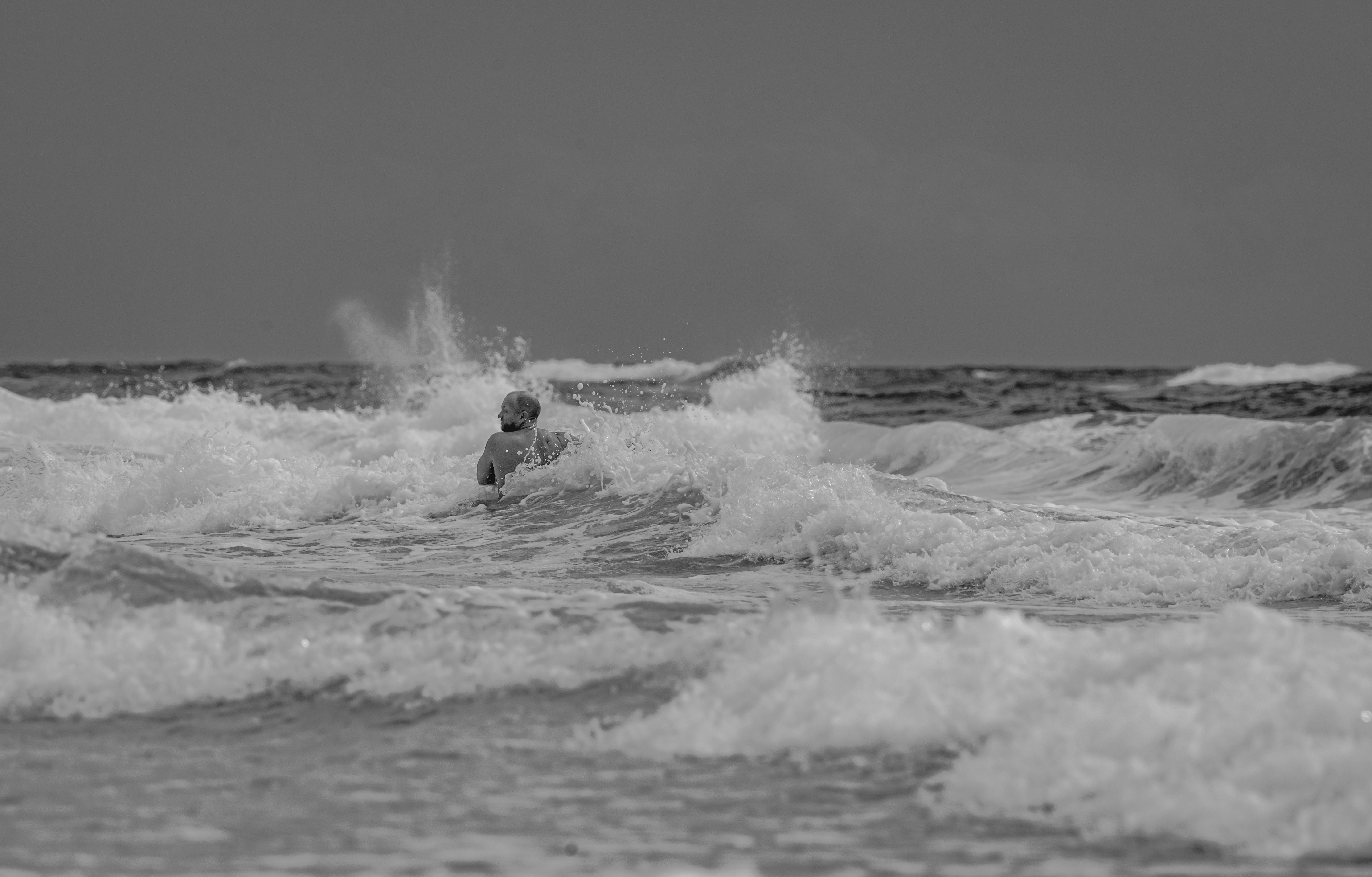 Grayscale Photo of Man in the Ocean · Free Stock Photo