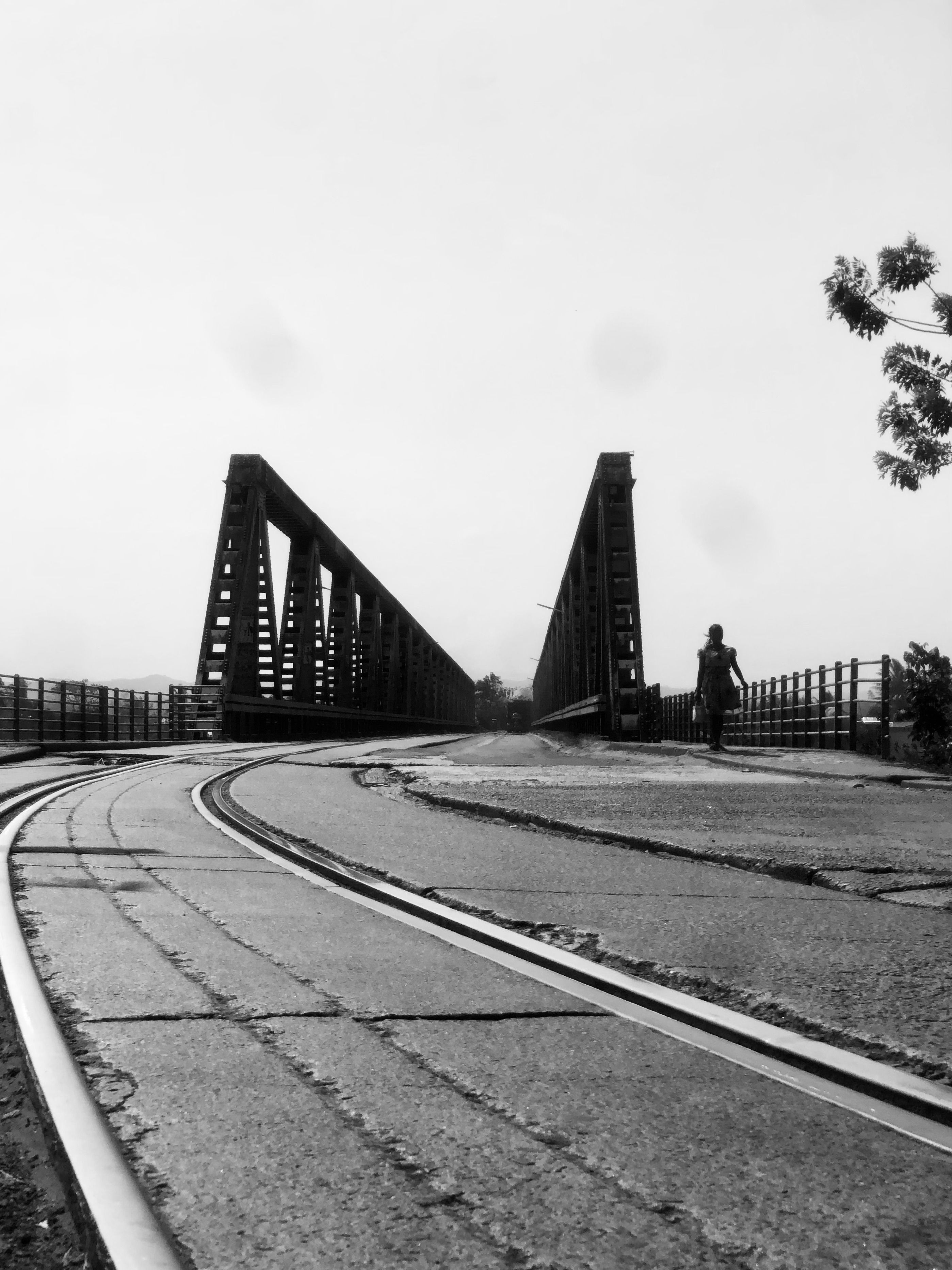 Grayscale Photo of Bridge Under Cloudy Sky · Free Stock Photo