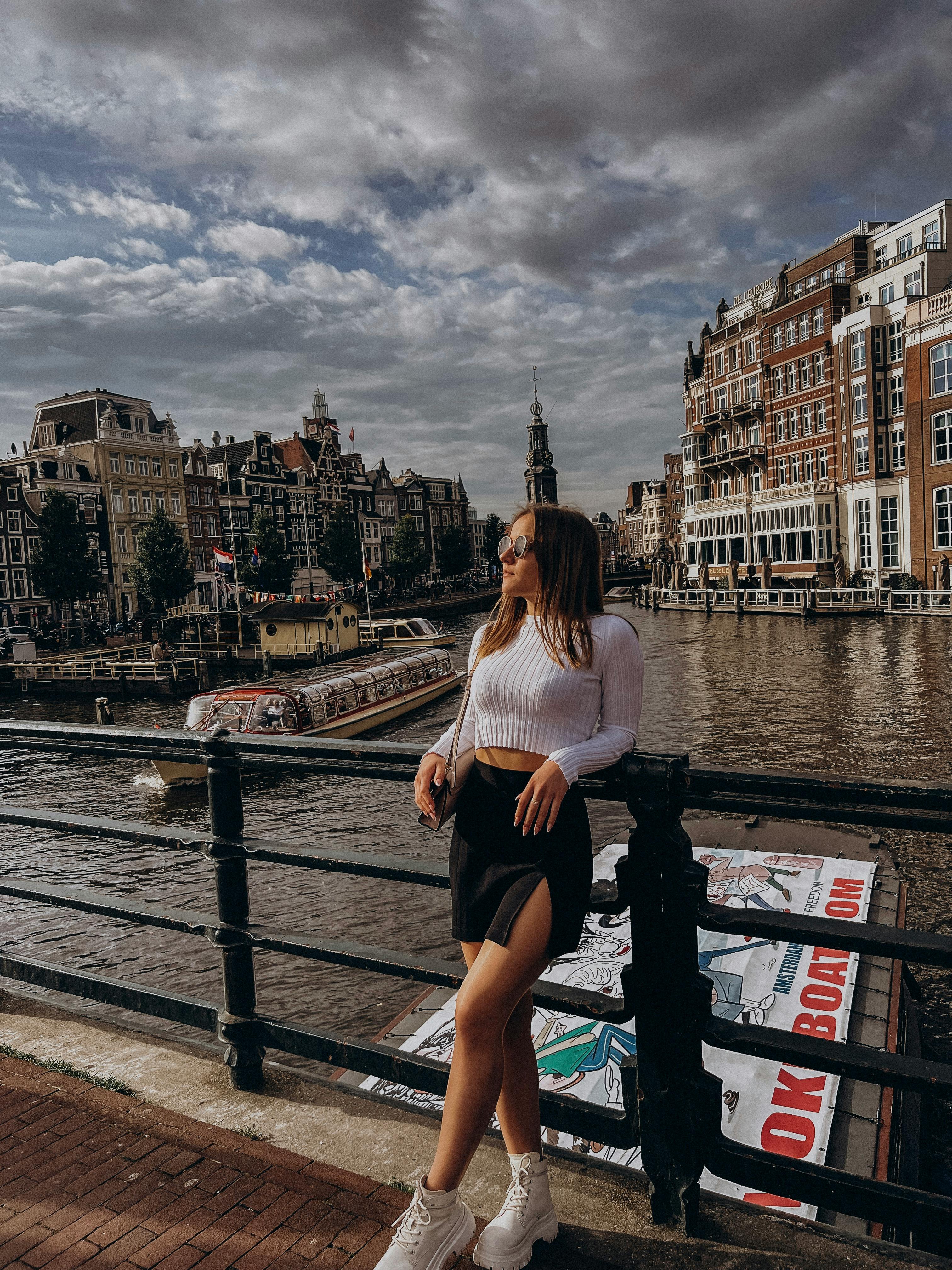 Woman Leaning on a Bridge Railing · Free Stock Photo