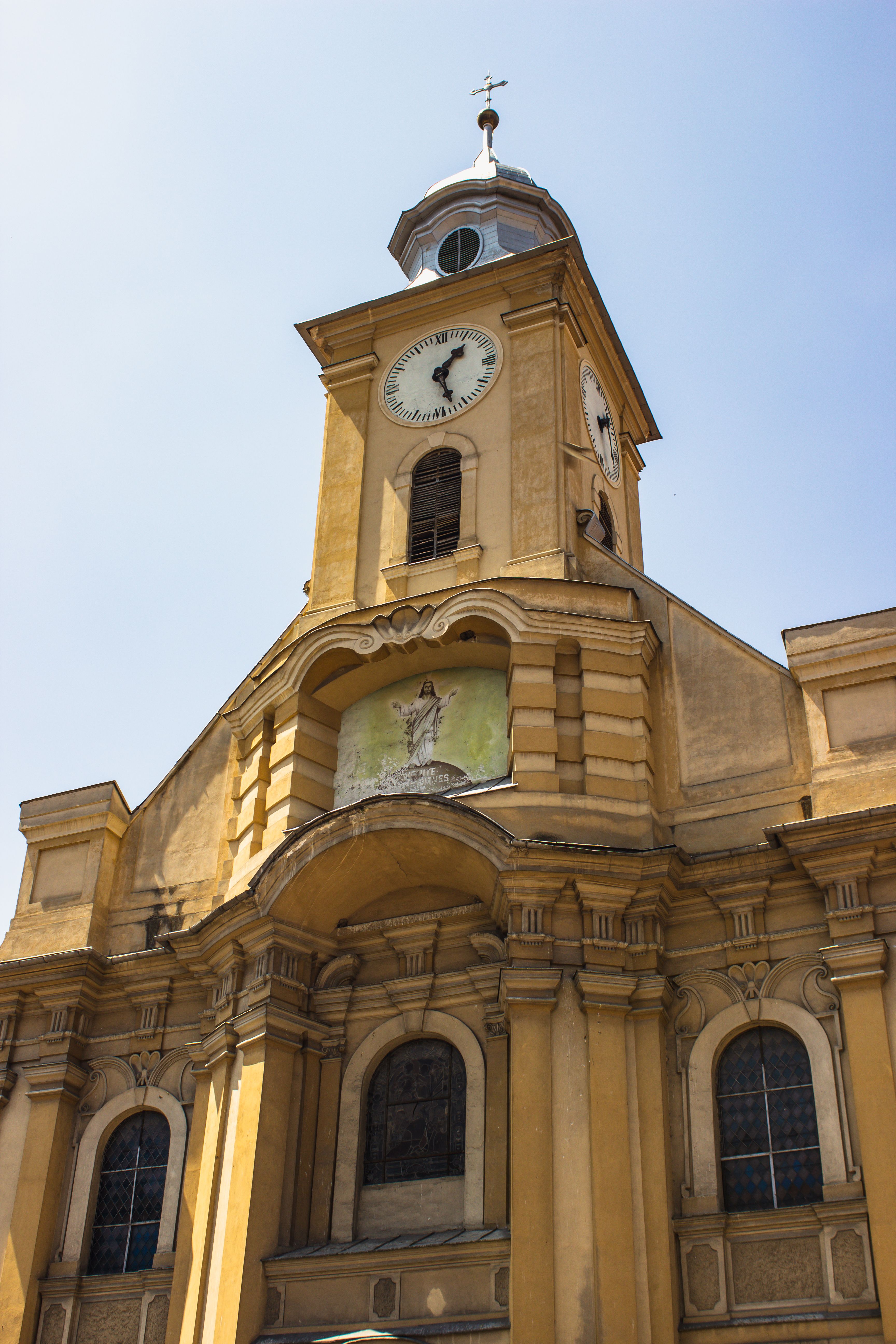 A Church Beside Brown Concrete Building · Free Stock Photo