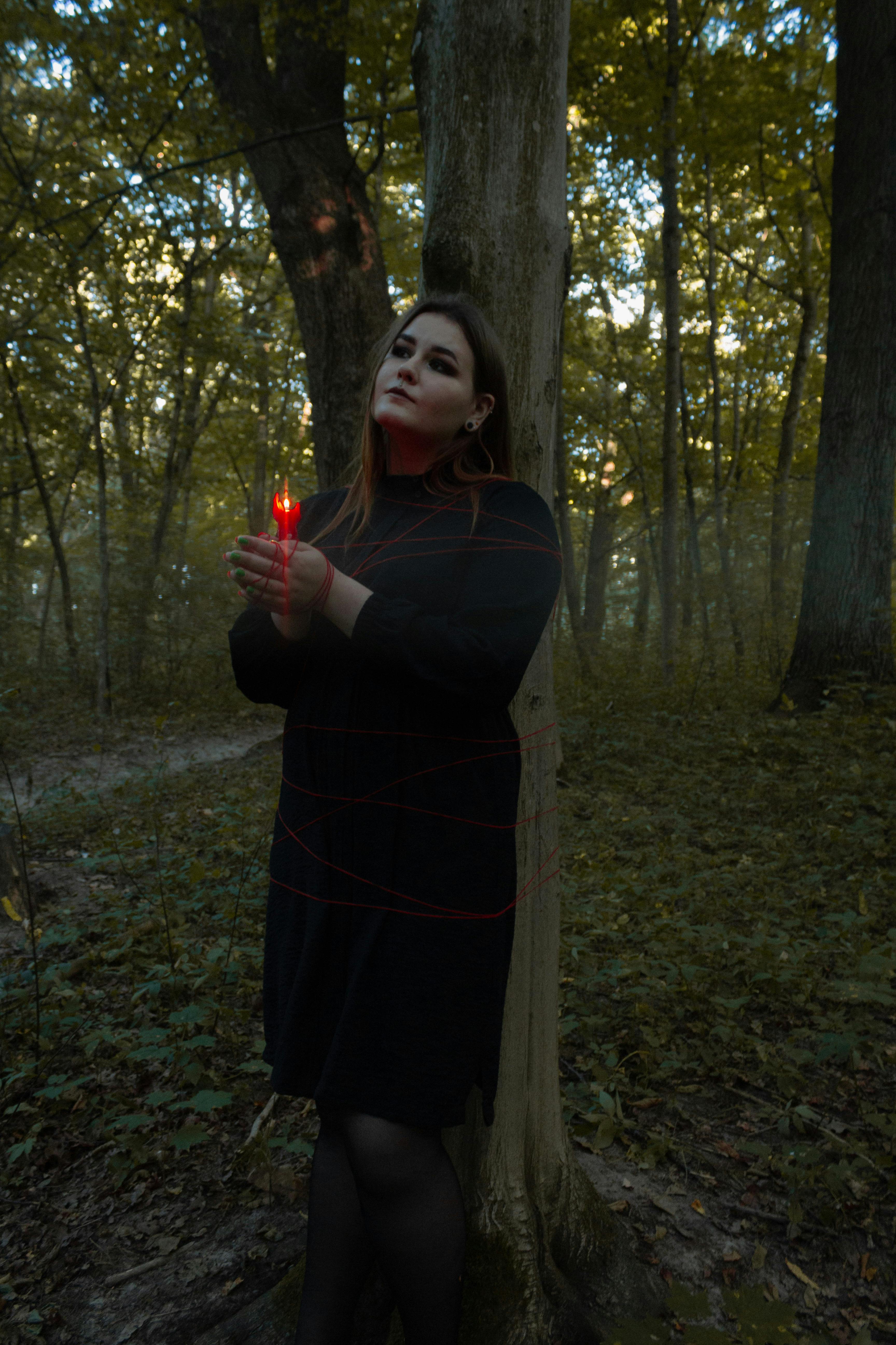 Tied to a Tree Woman Holding a Candle · Free Stock Photo