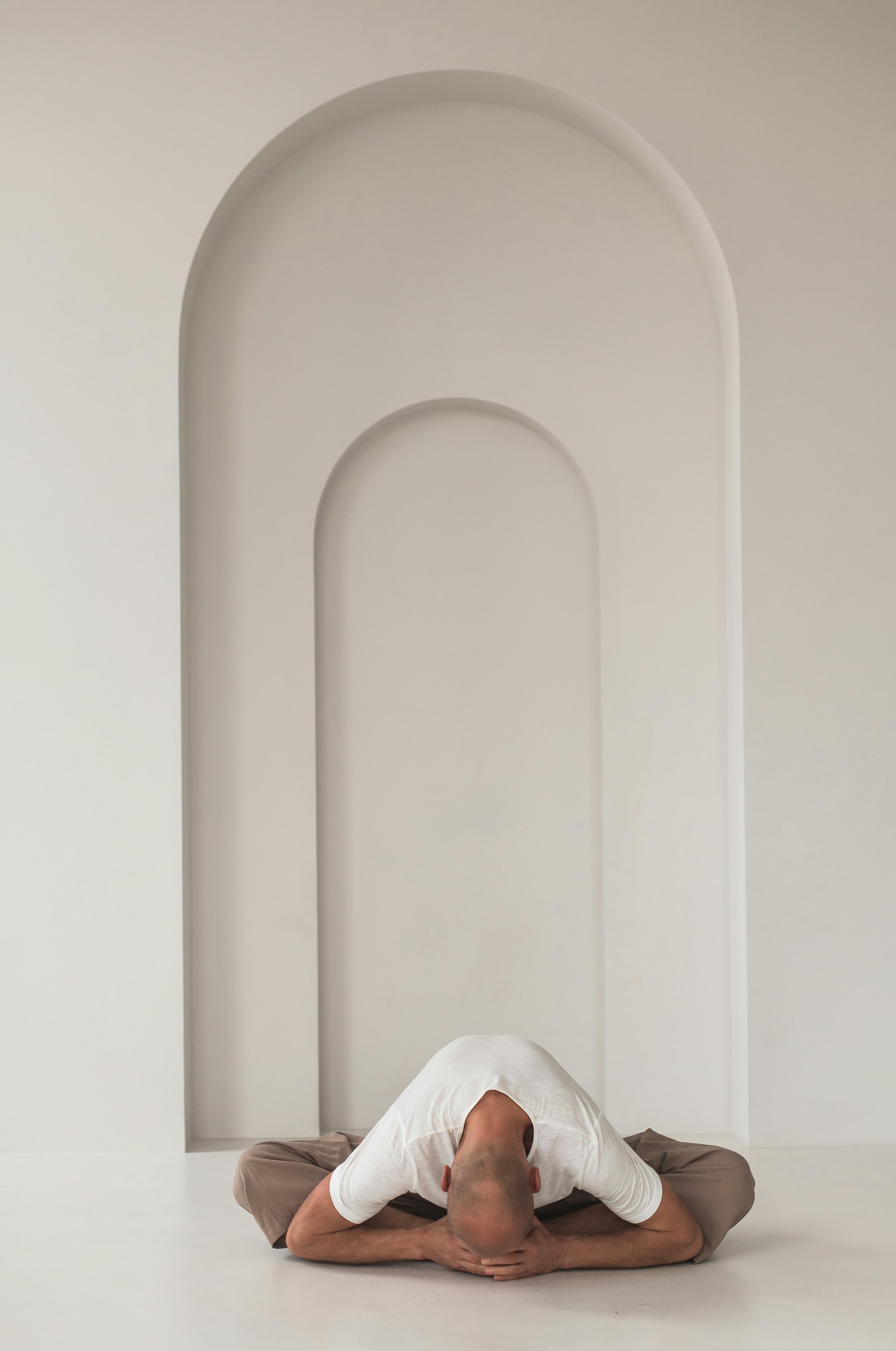 A Person Sitting on the White Concrete Floor · Free Stock Photo