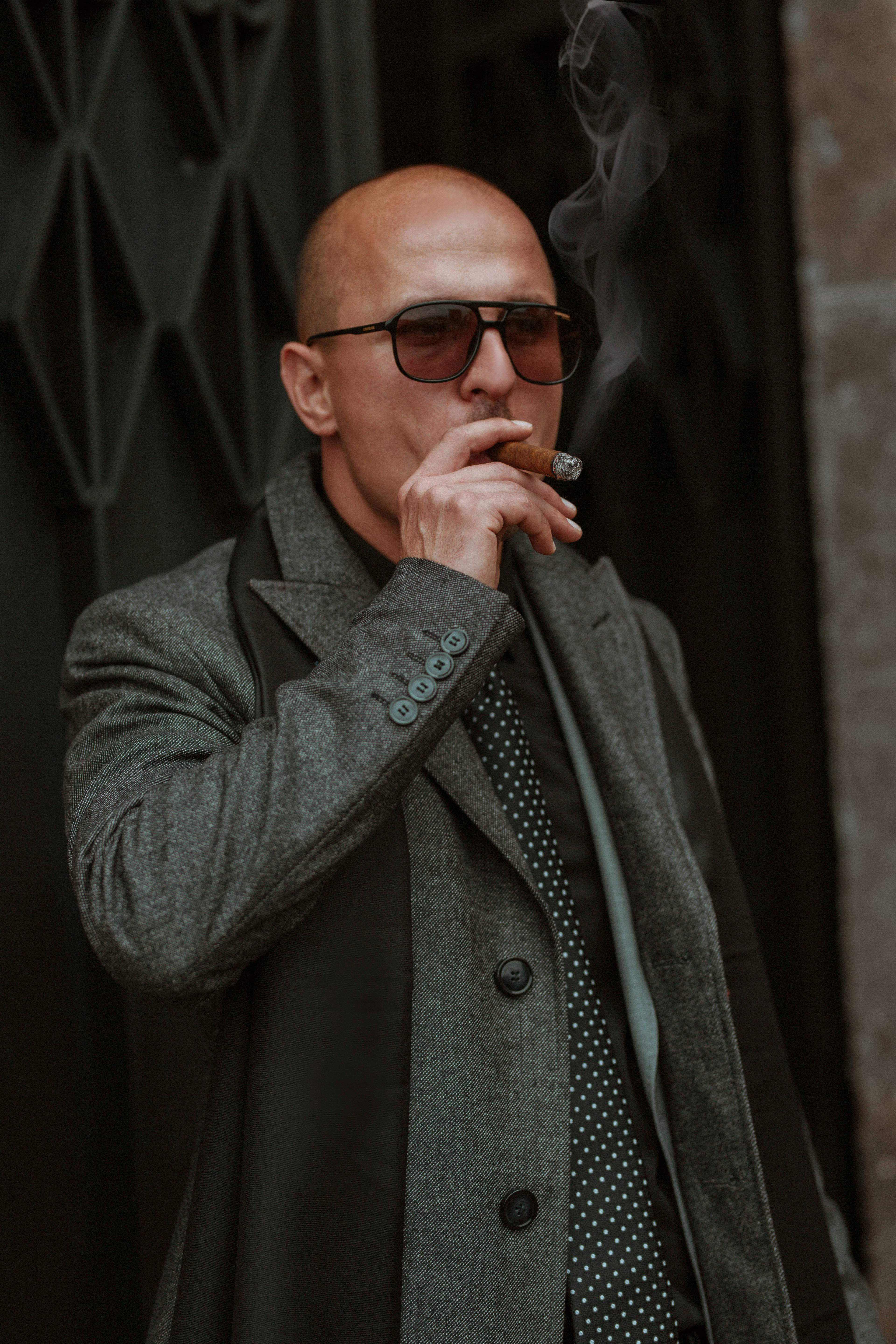 A Man in a Black Coat Smoking a Cigar · Free Stock Photo