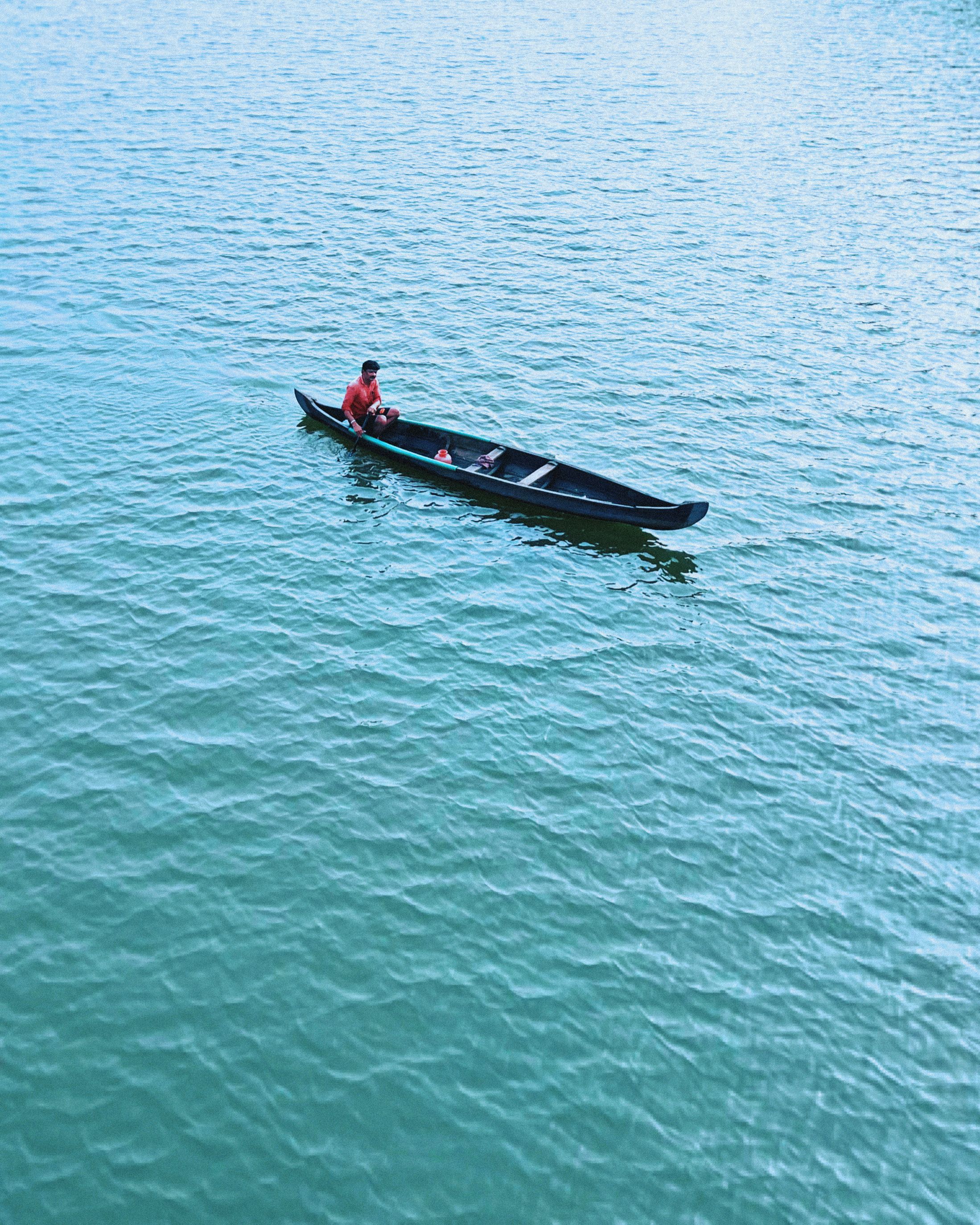 Man Sitting Alone on a Boat · Free Stock Photo