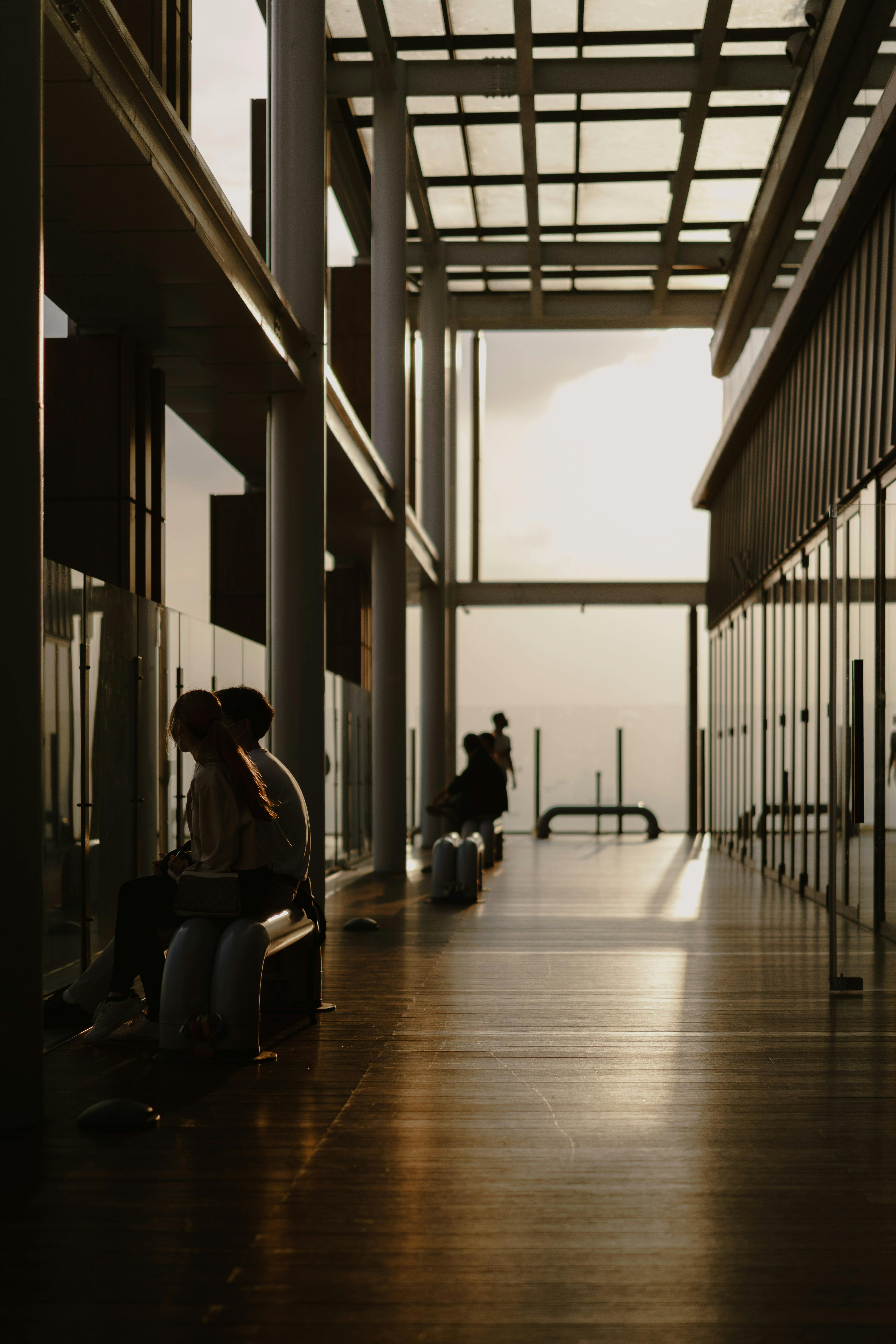 People Sitting on the Hallway of a Building · Free Stock Photo