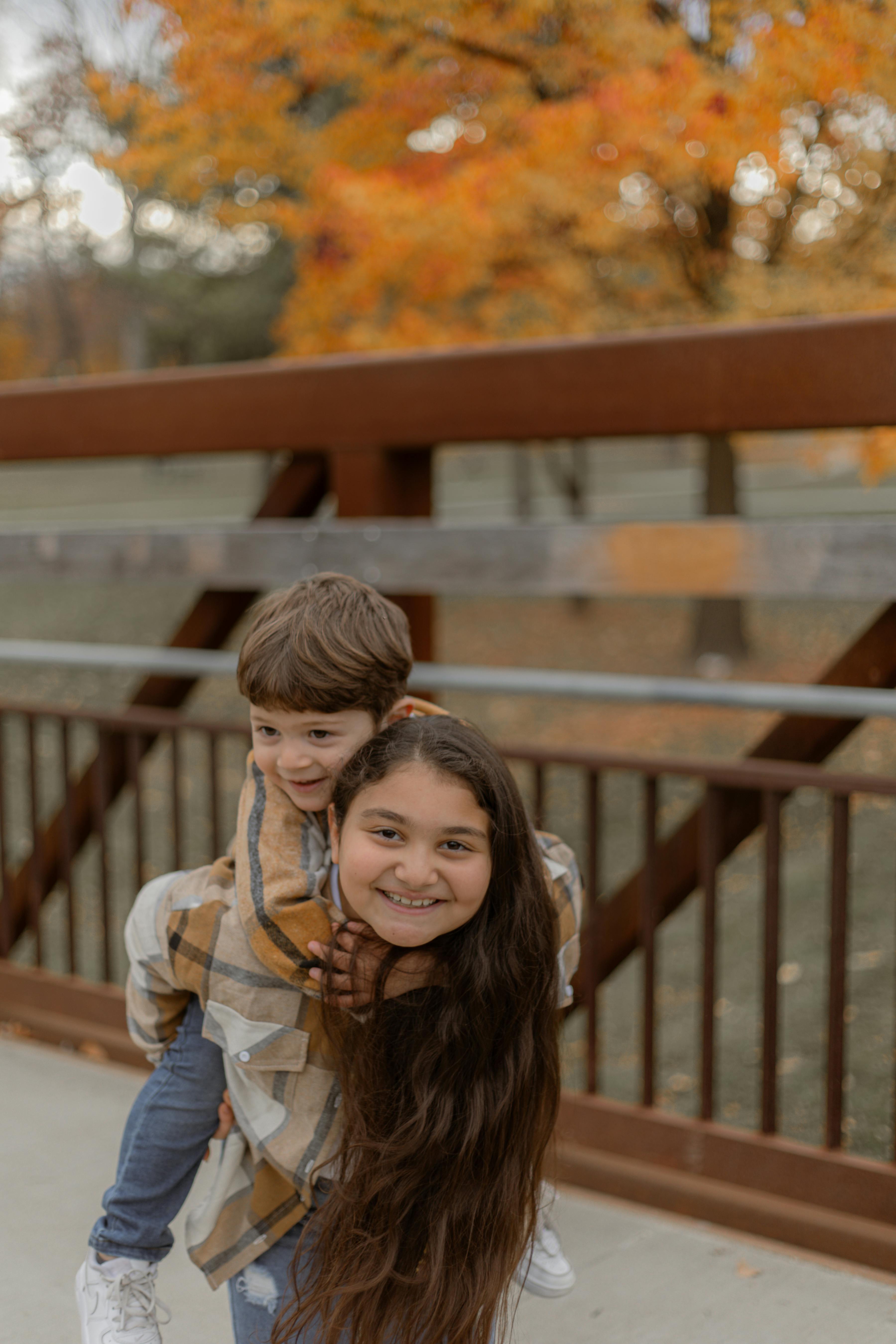 A Teenage Girl Holding her Younger Sister · Free Stock Photo