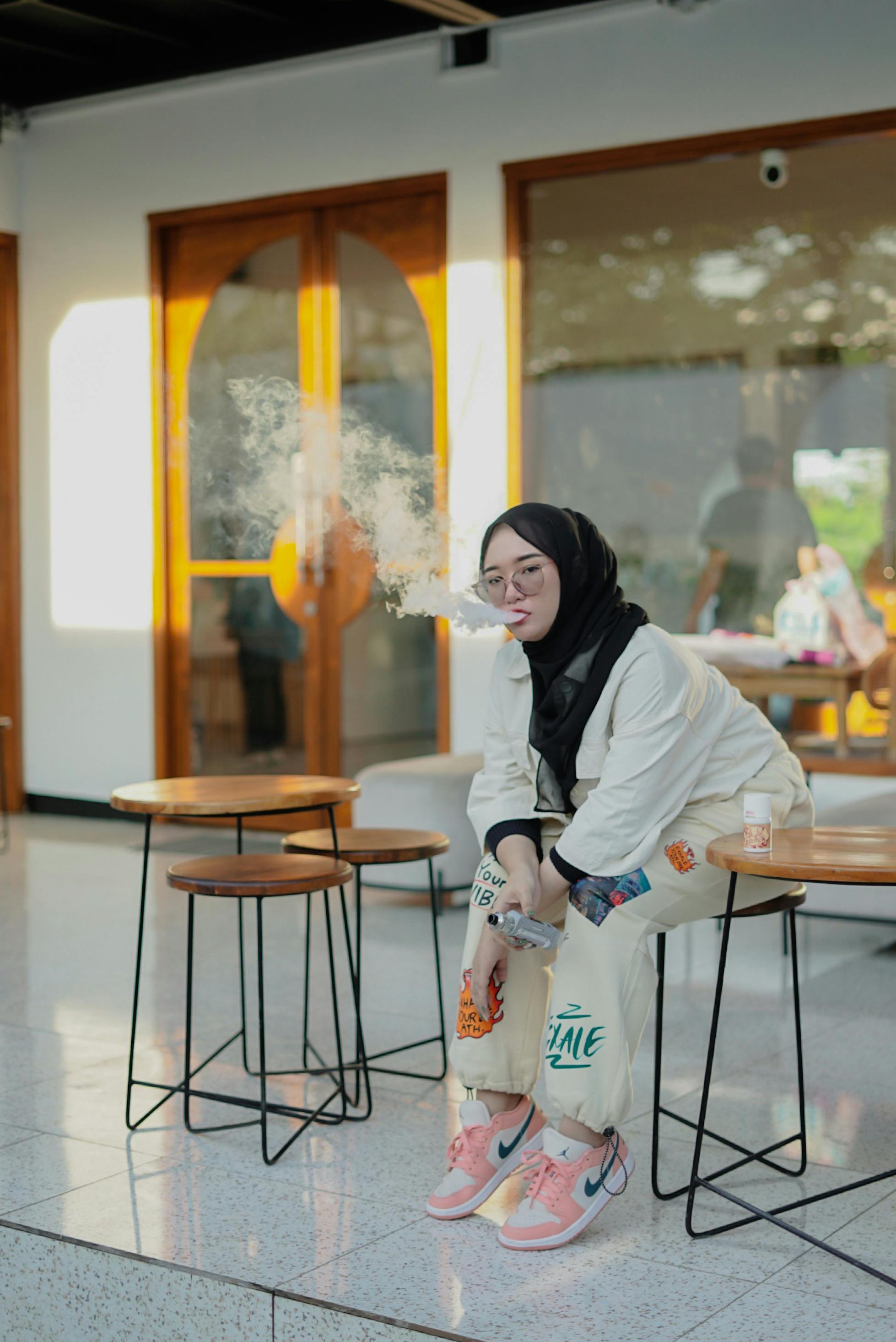 Woman Sitting on Stairs While Vaping · Free Stock Photo
