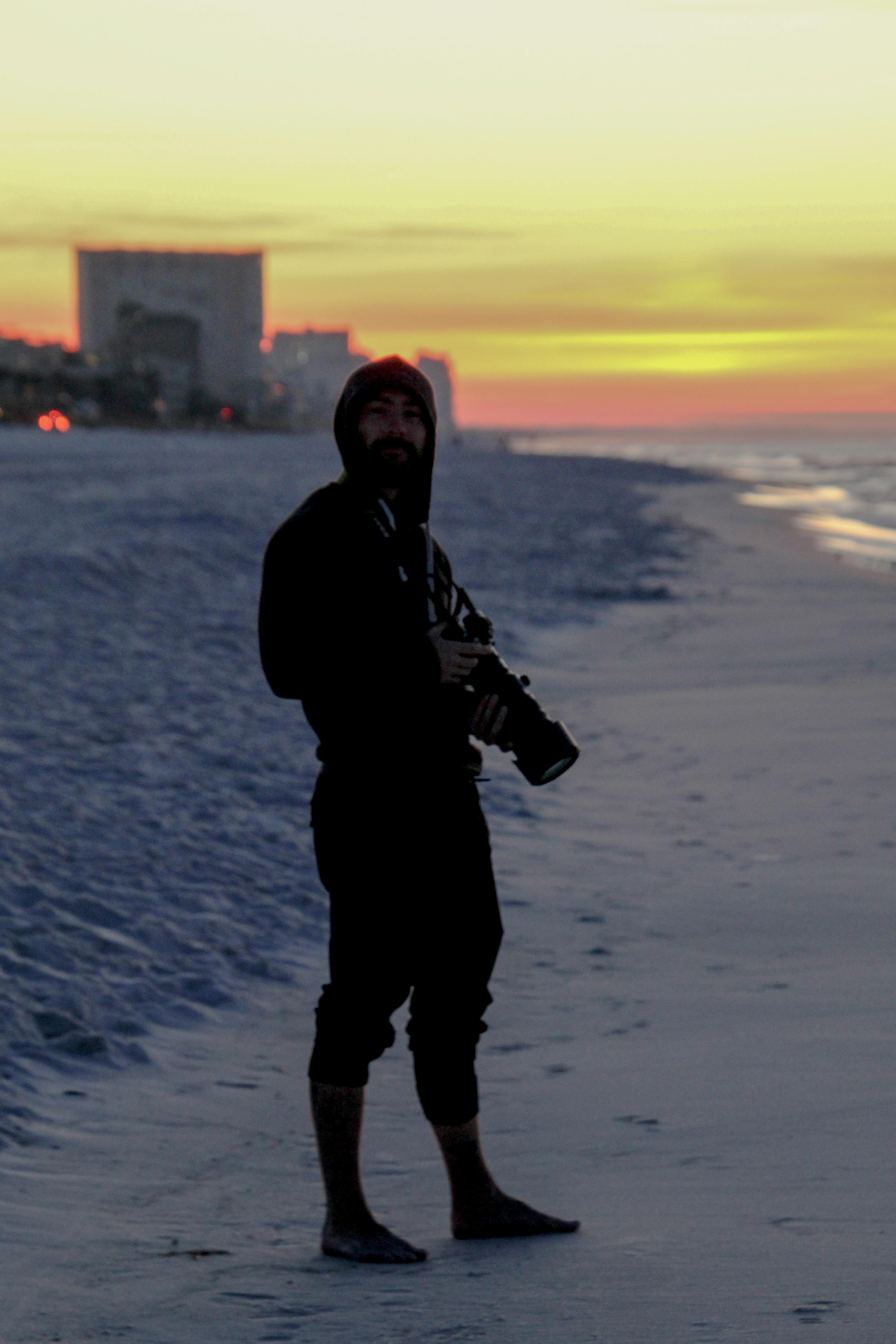 Man Holding a Camera while Standing on the Beach during Sunset · Free ...
