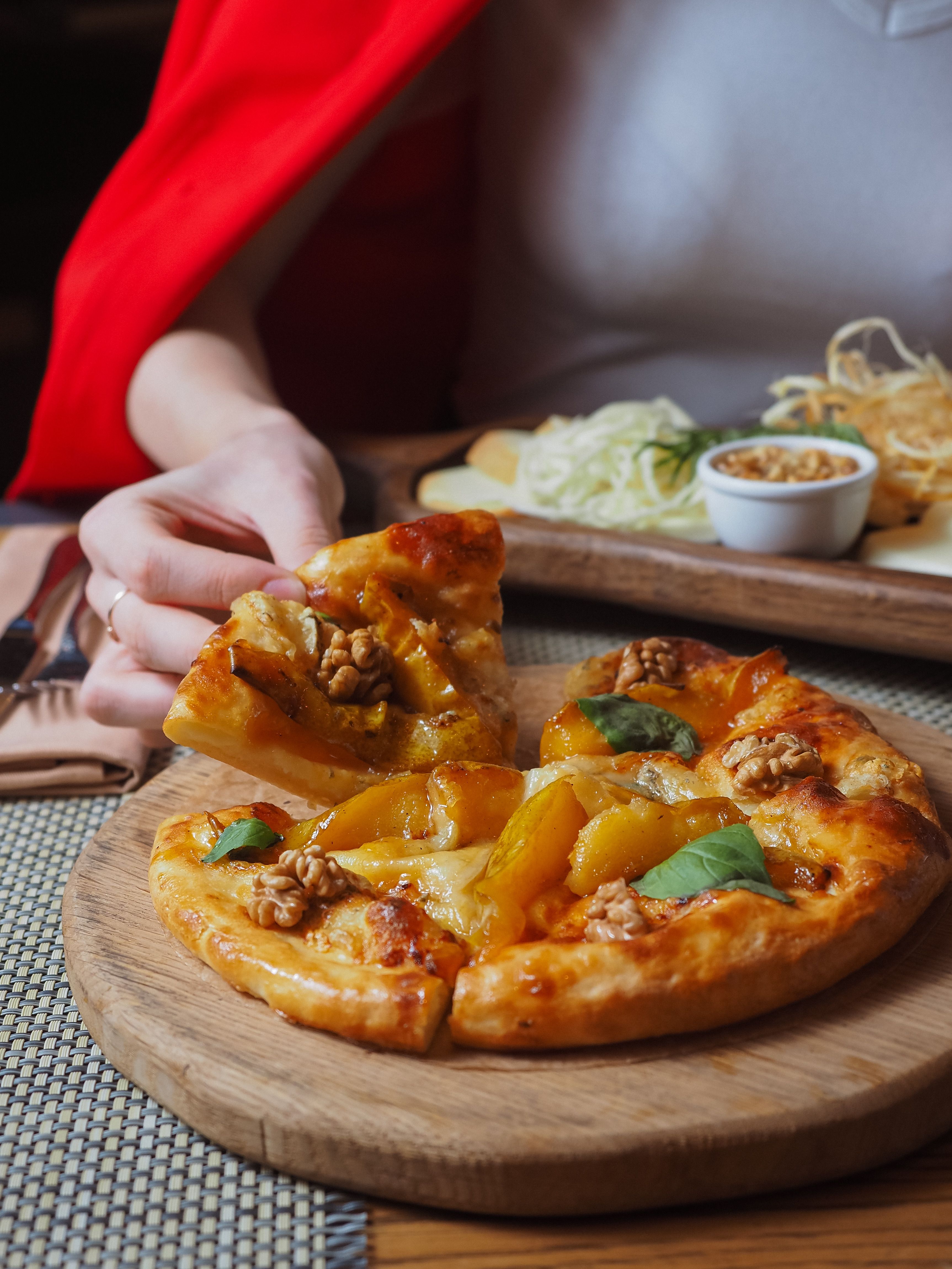 Woman Eating Delicious Pizza at Table · Free Stock Photo