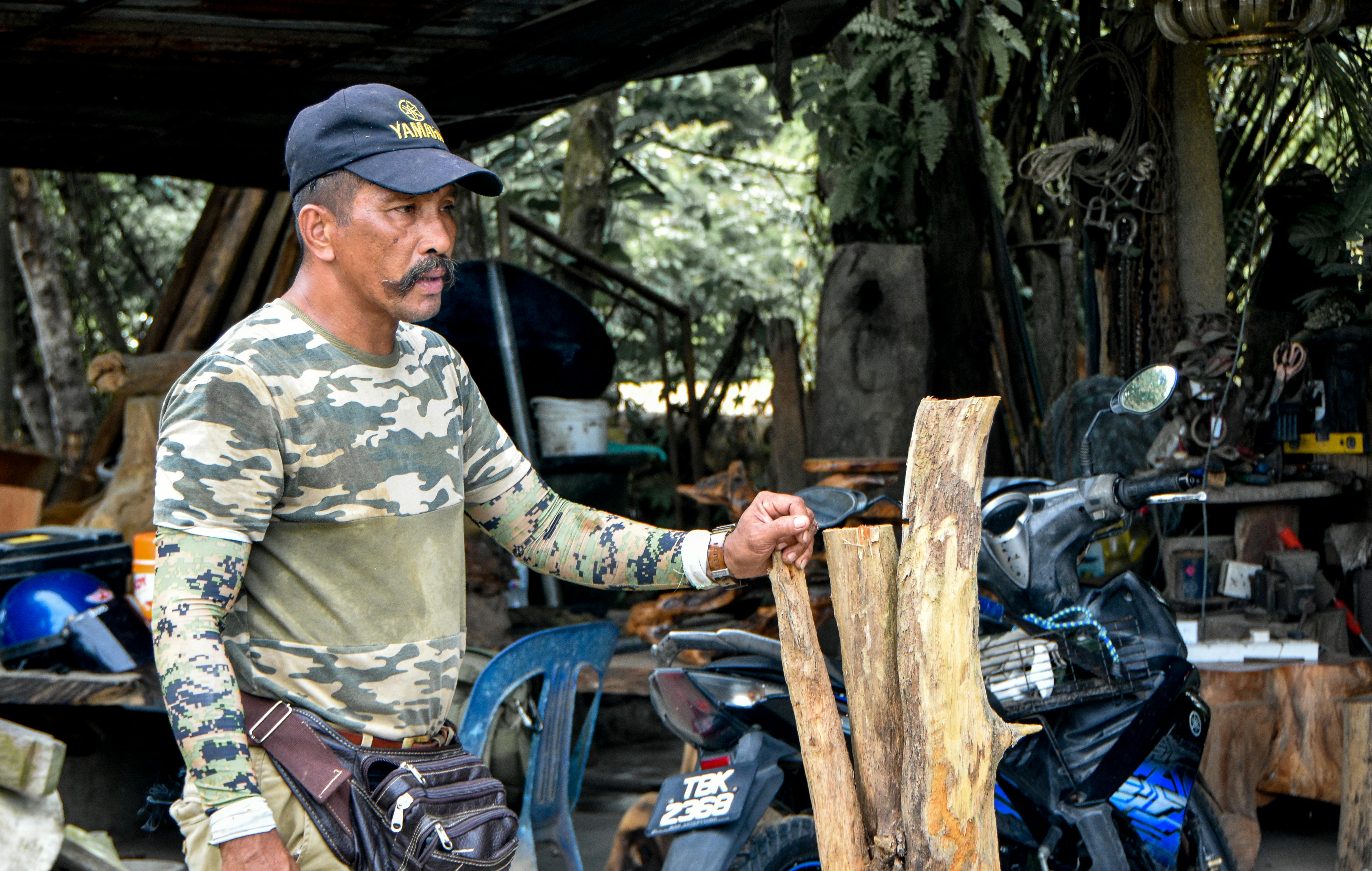 Man Wearing Camo Shirt Standing in front of Outdoor Repair Shop · Free ...