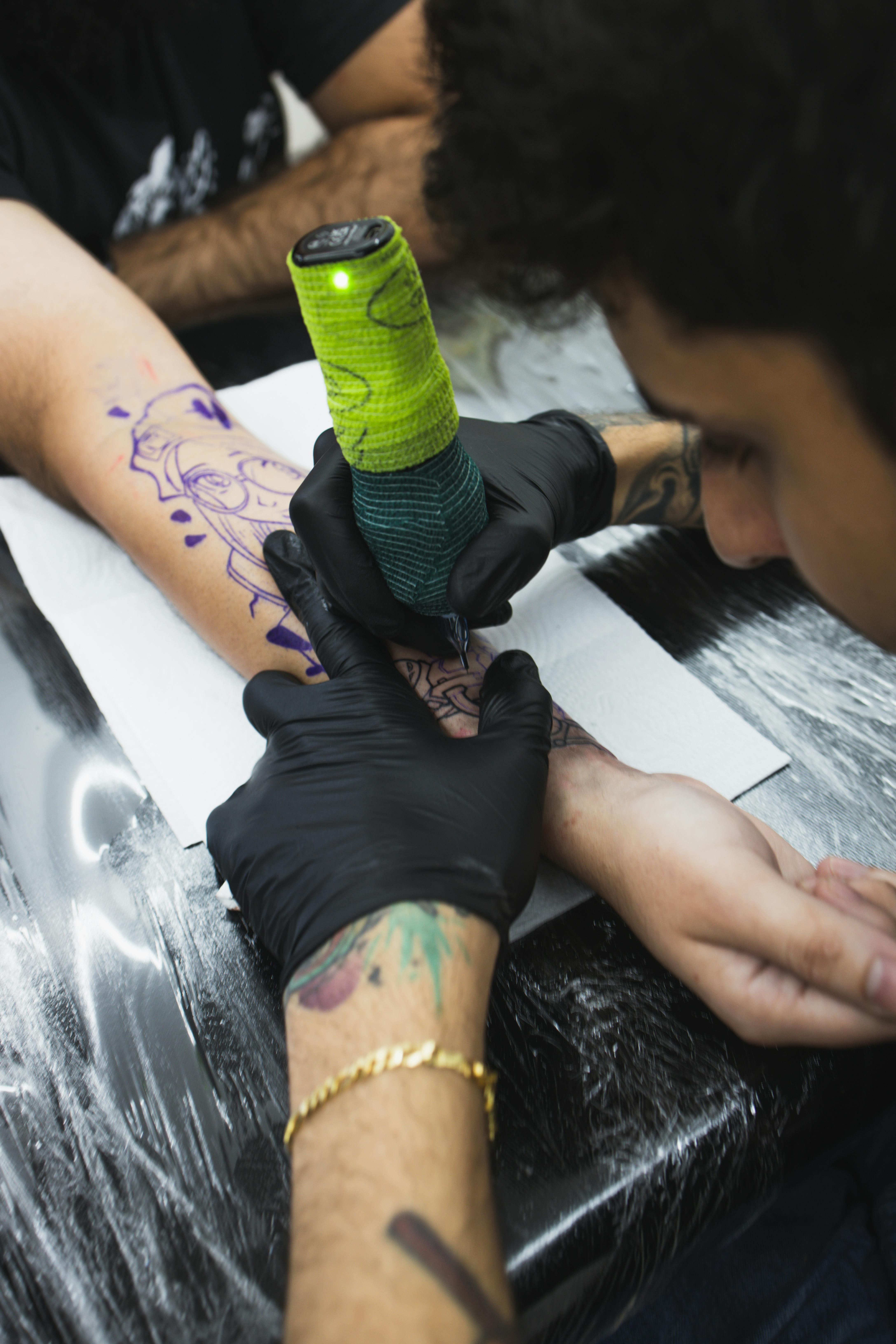 Tattoo Artist Drawing on a Person's Arm · Free Stock Photo