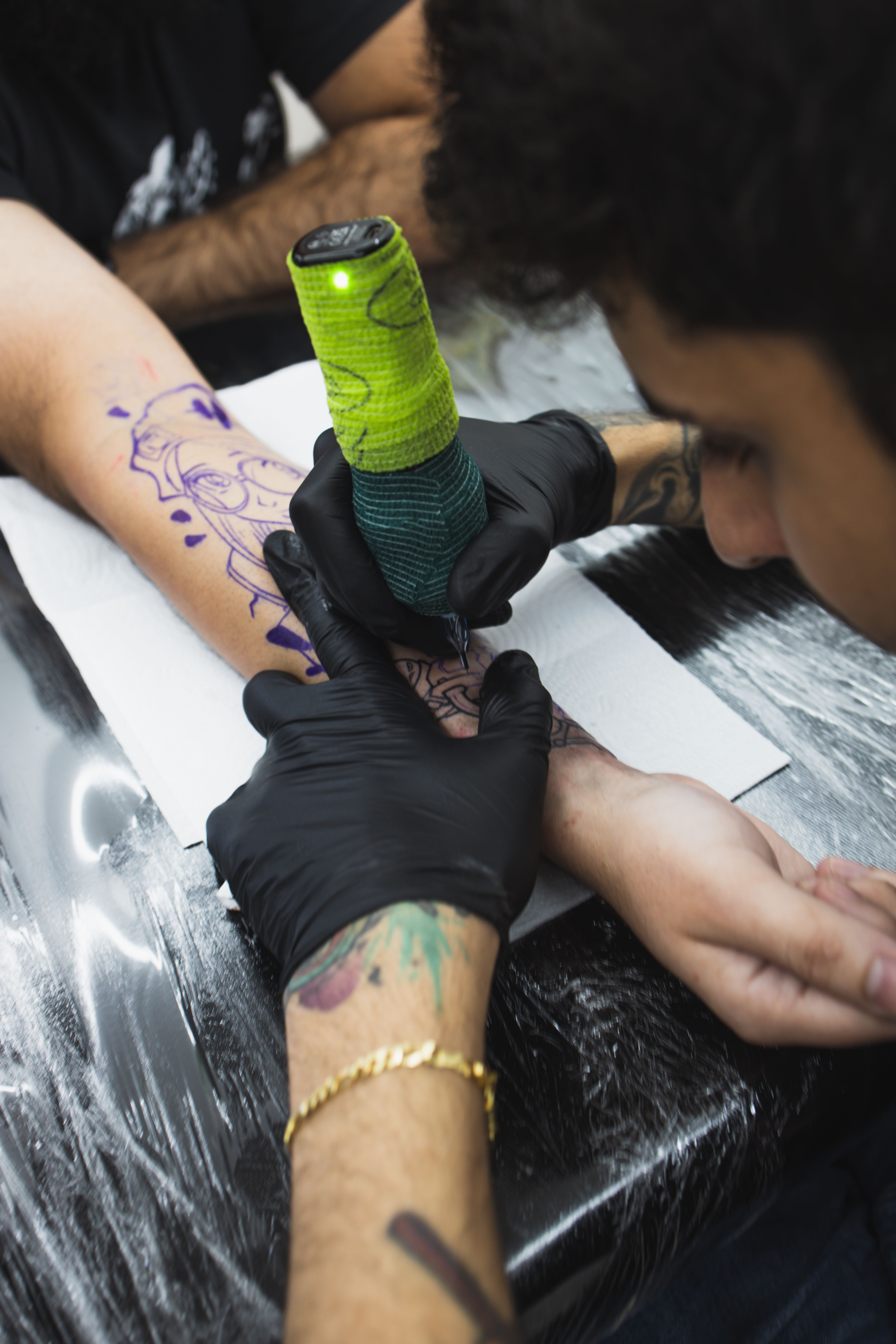 Man Holding Tattoo Machine And Tattooing Person Arm · Free Stock Photo