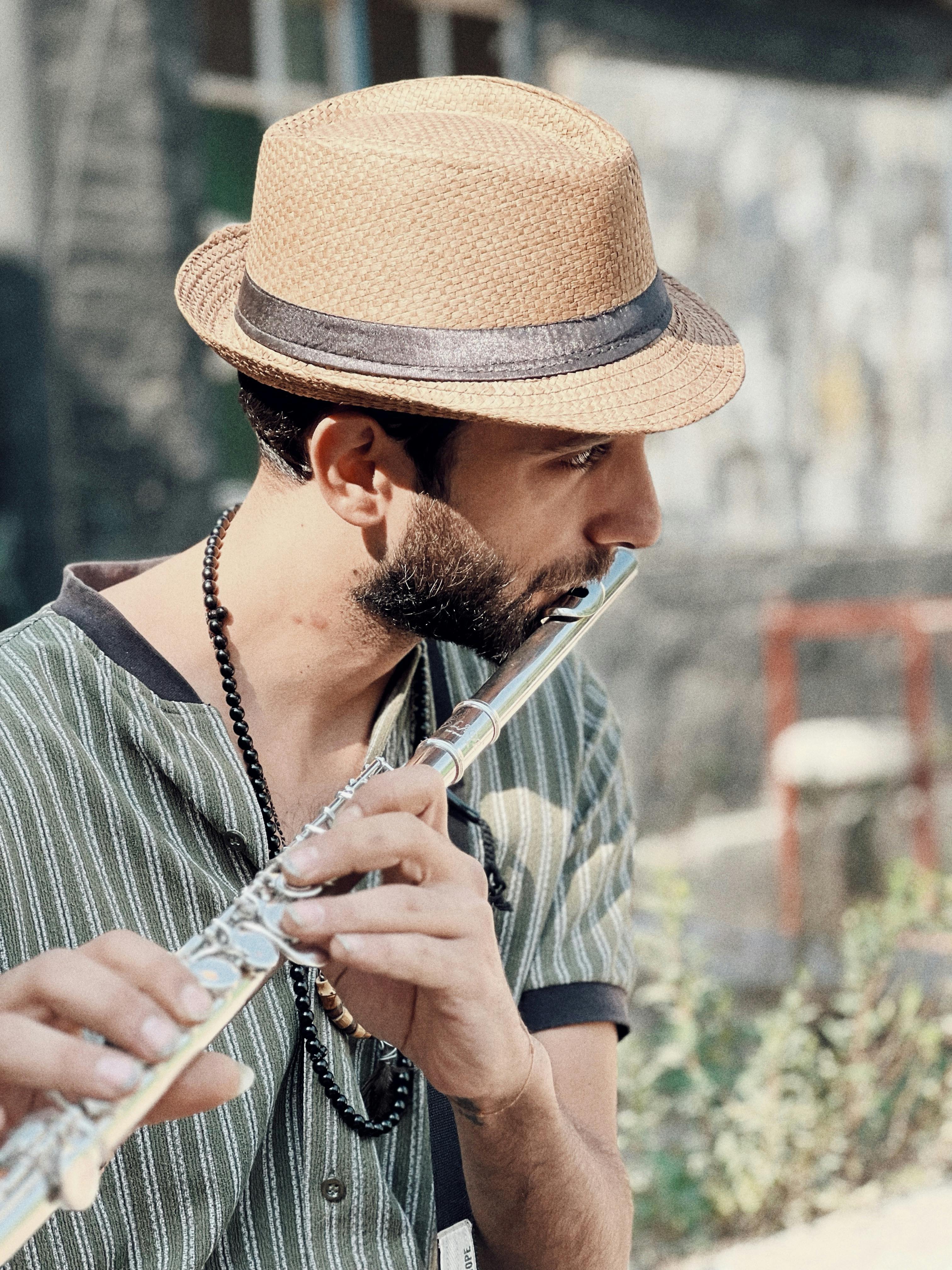 Man in a White and Black Stripe Shirt Playing the Flute · Free Stock Photo