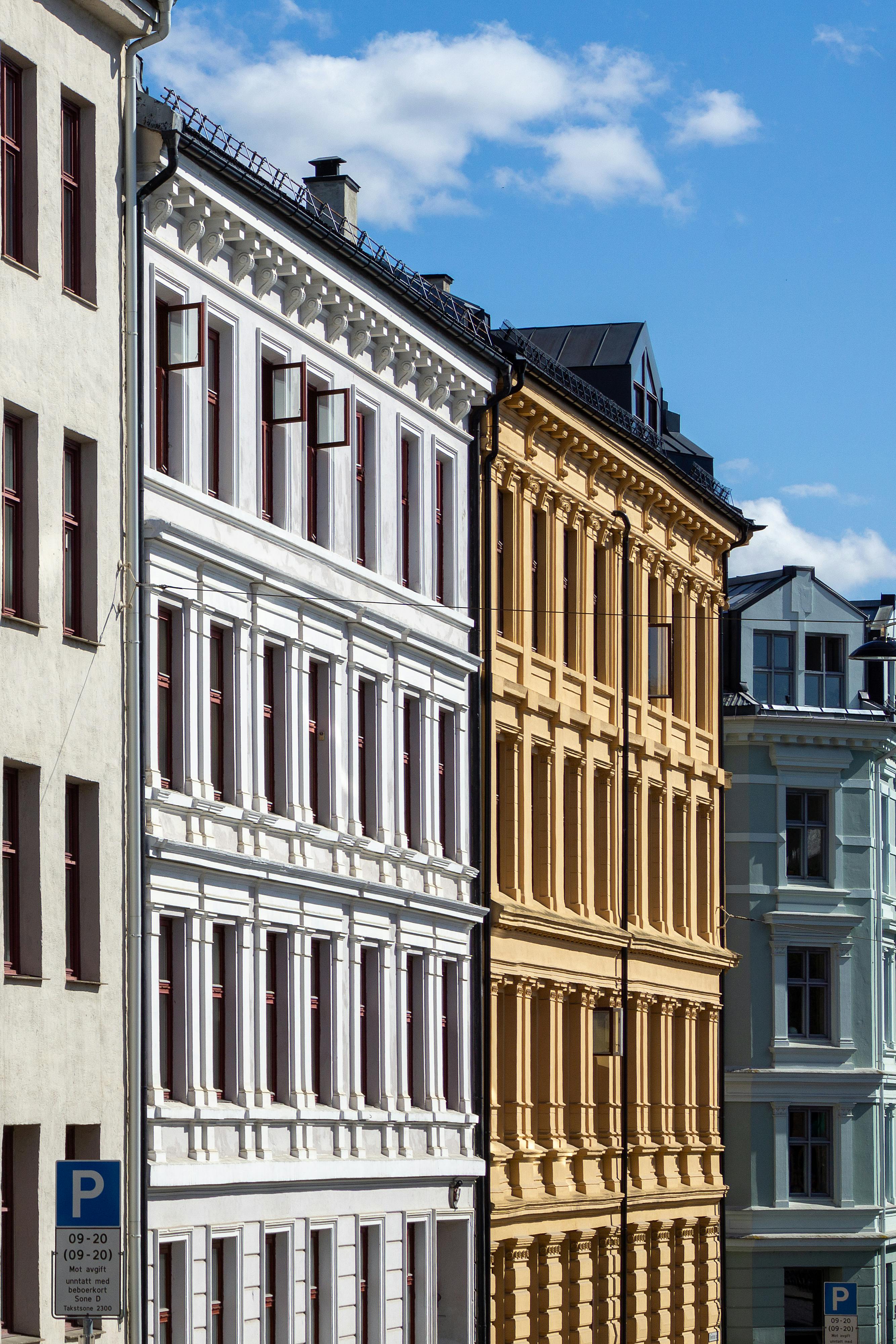White and Yellow Concrete Buildings Under a Blue Sky · Free Stock Photo