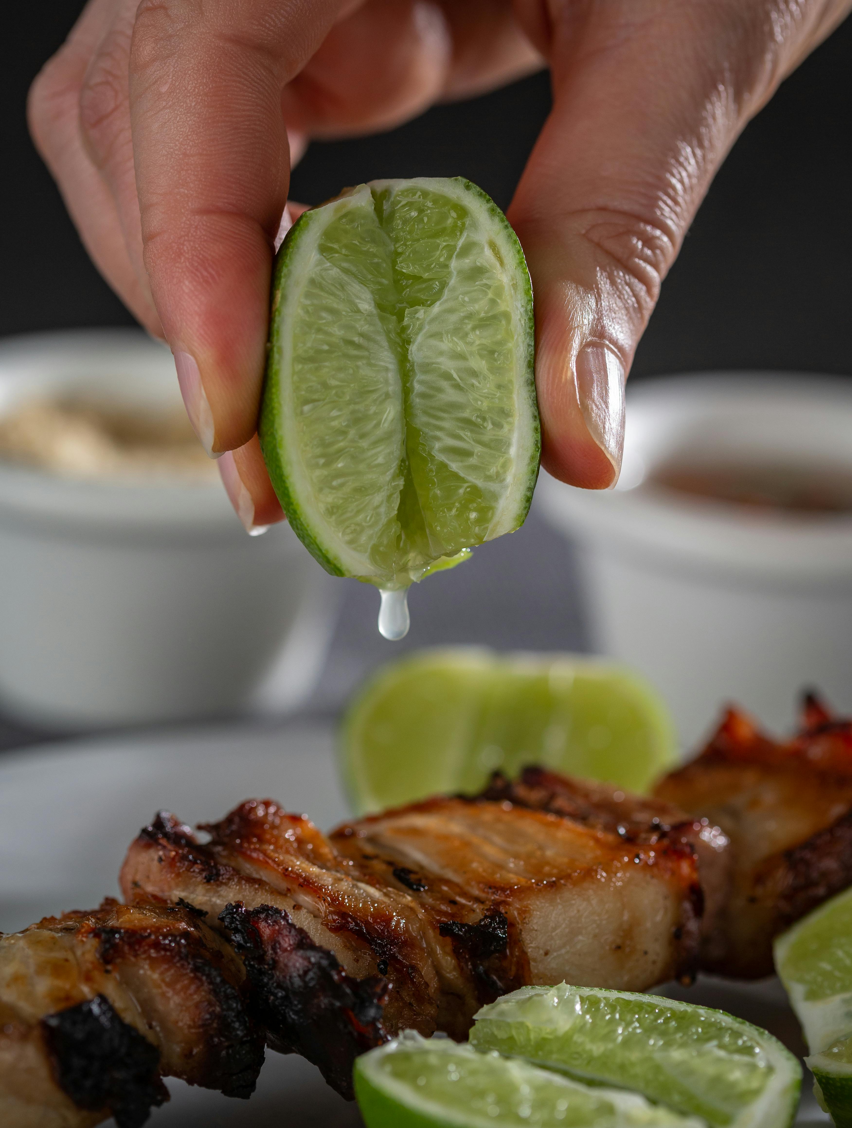 A Person Squeezing Lime on Wrapped Food · Free Stock Photo