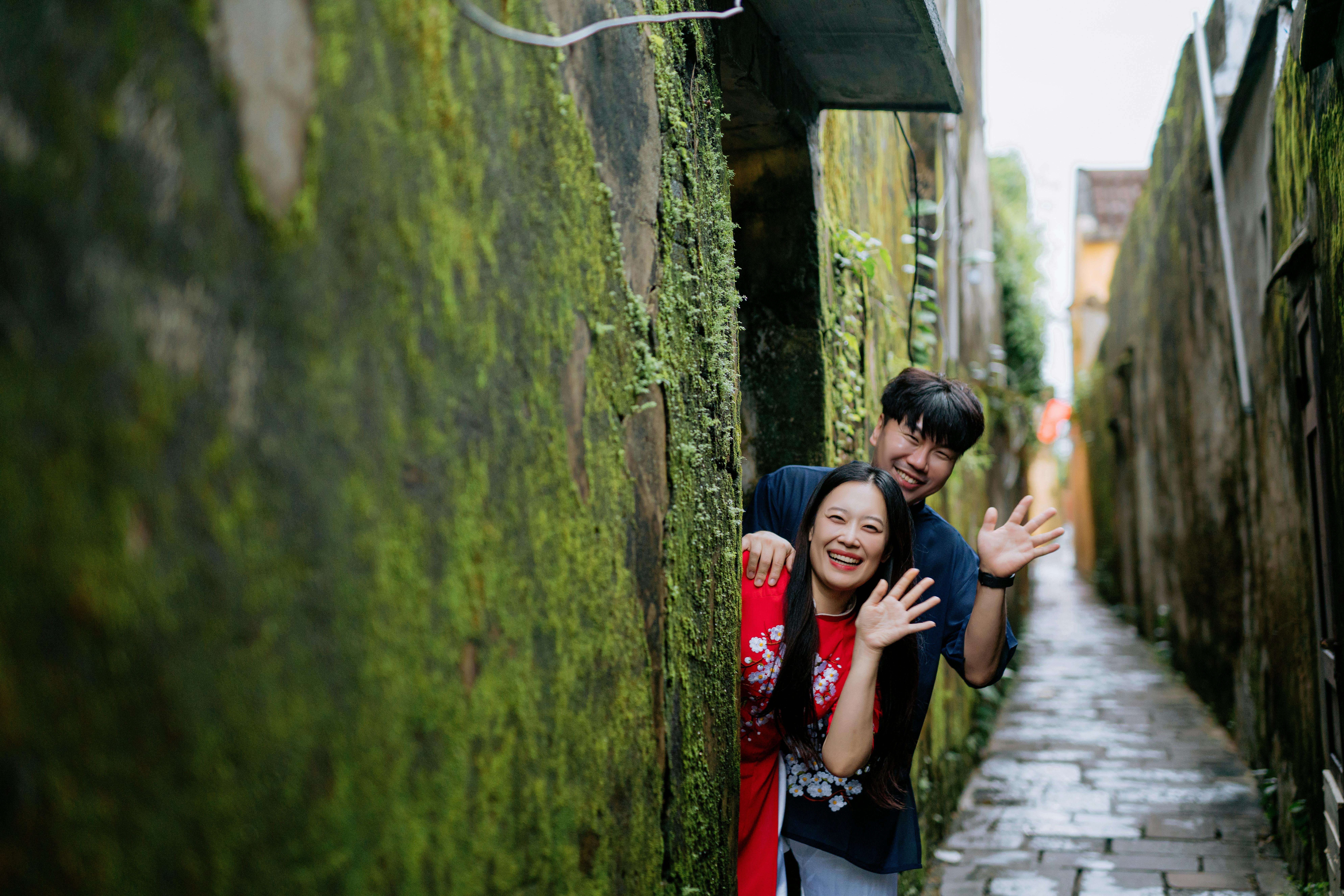 Photo of a Couple Smiling while Waving Their Hands · Free Stock Photo
