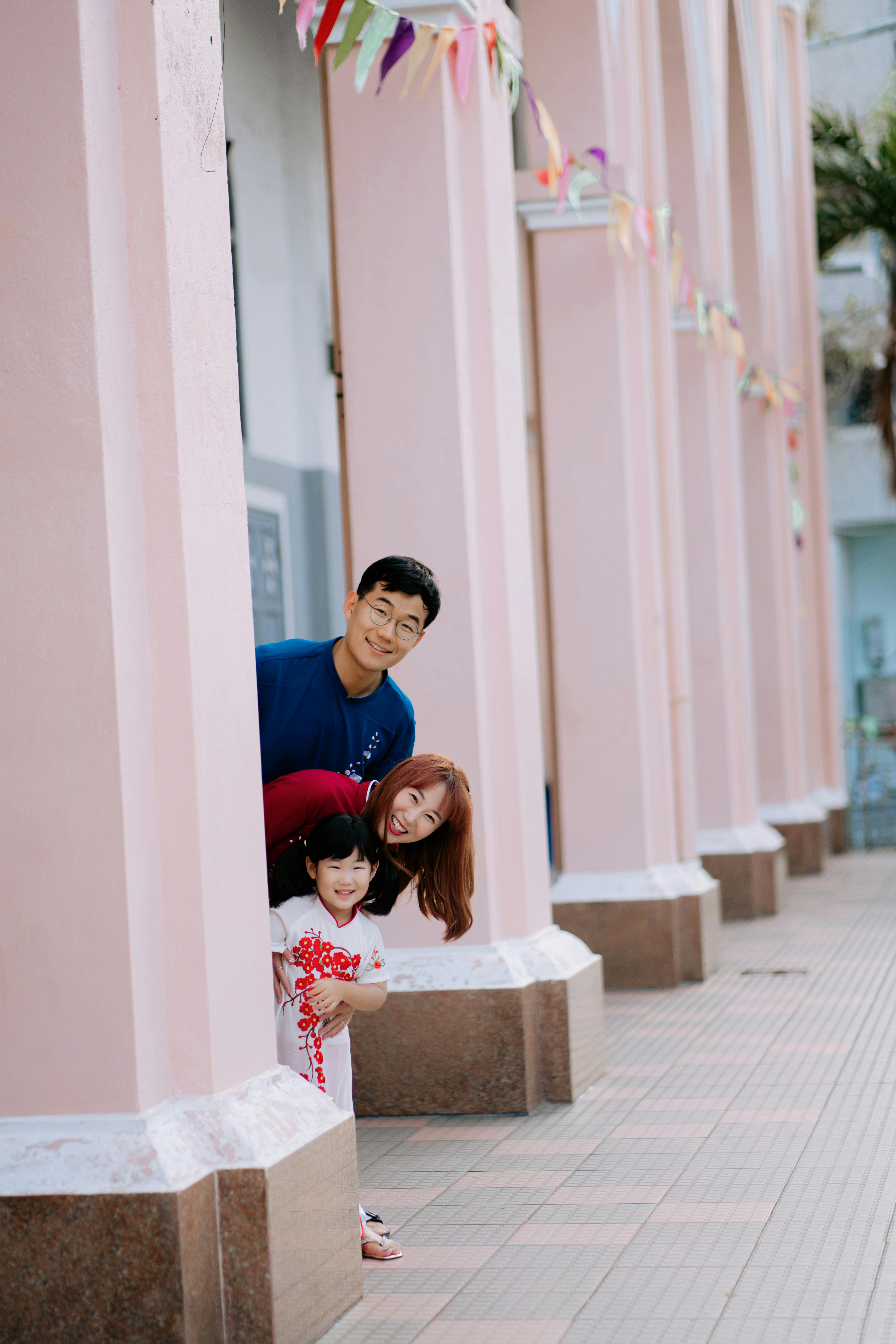 Photo of a Family Hiding and Smiling next to a Light Pink Column · Free ...