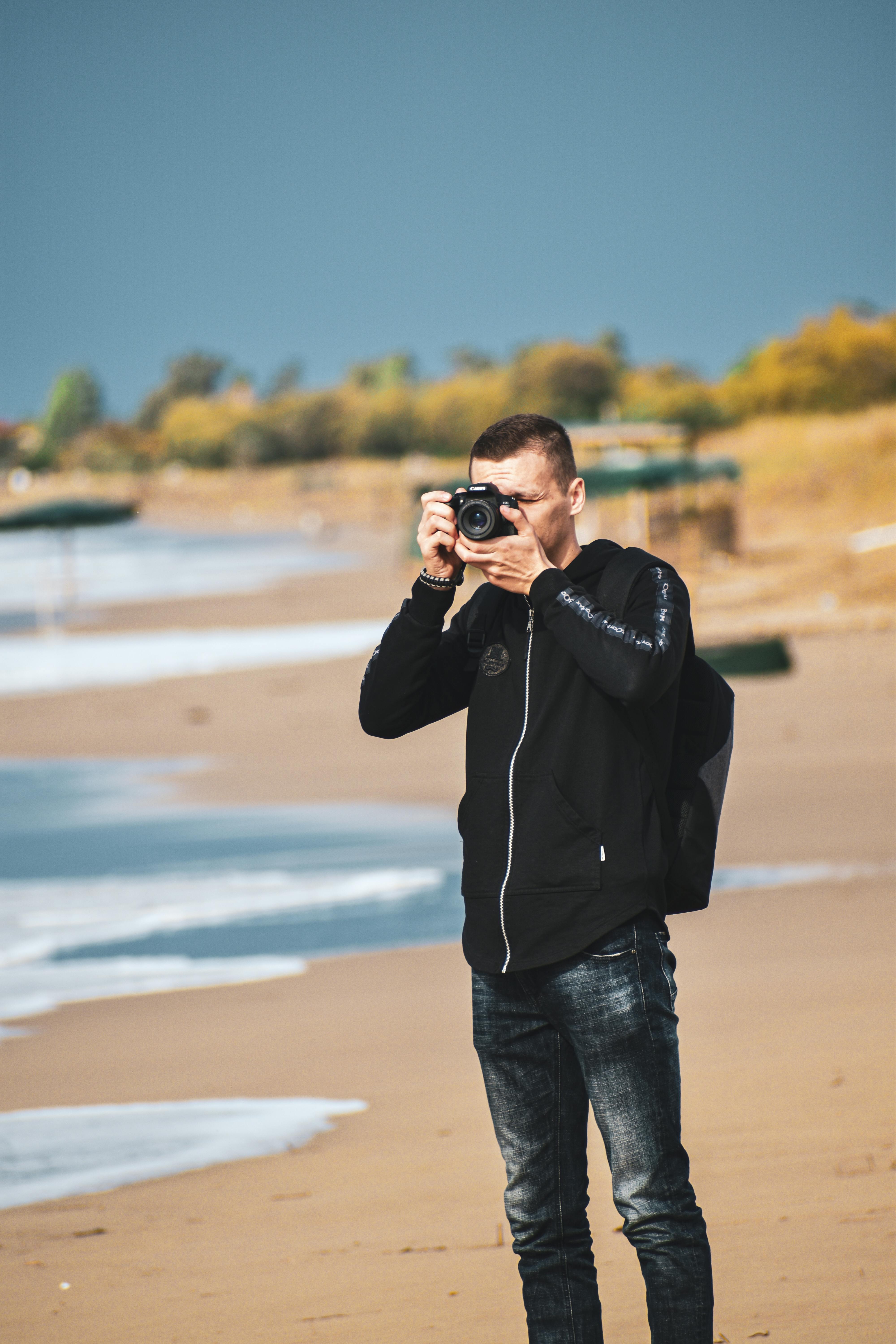 A Man Using Black DSLR Camera · Free Stock Photo