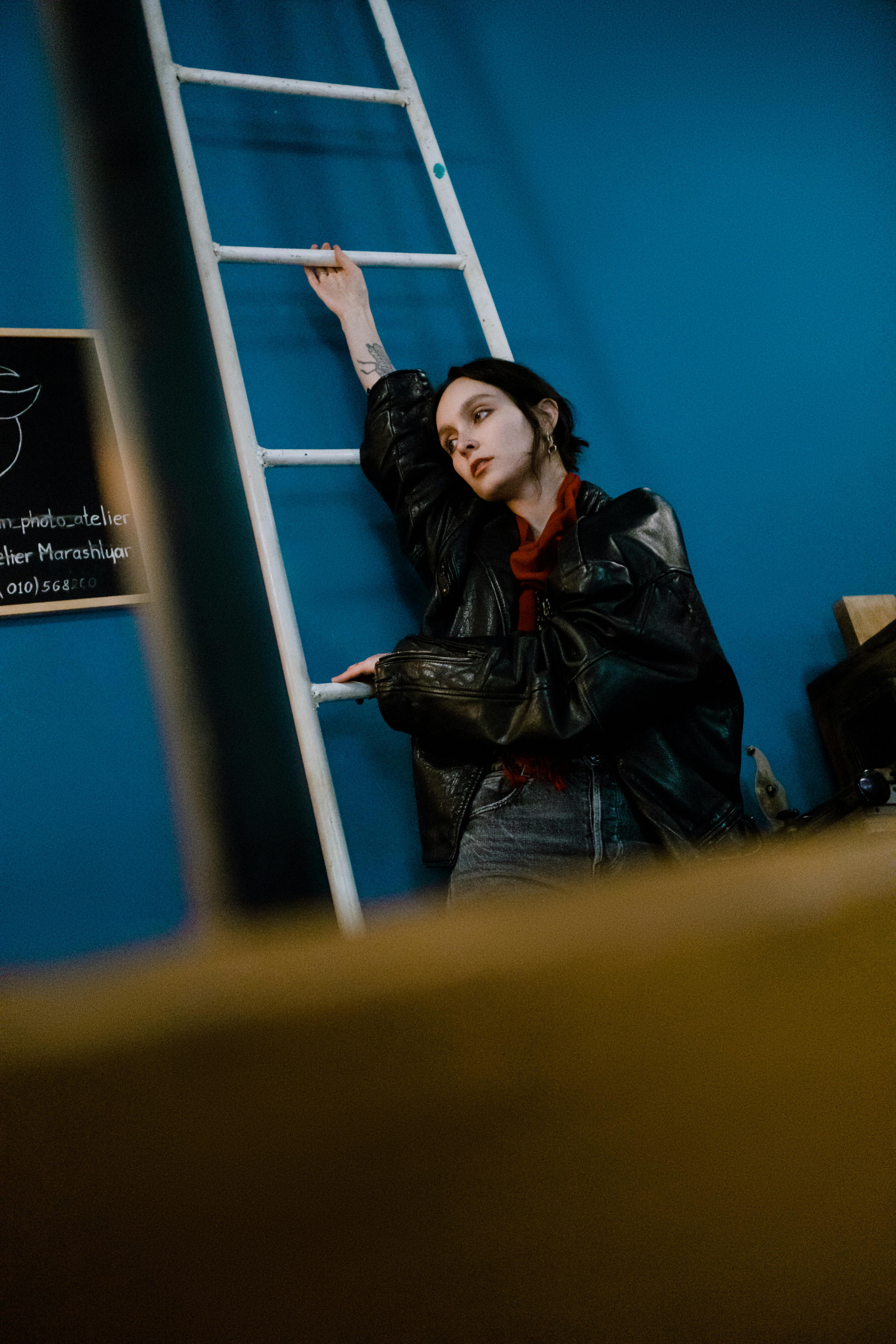 Woman in a Black Leather Jacket Posing Beside a White Ladder · Free ...