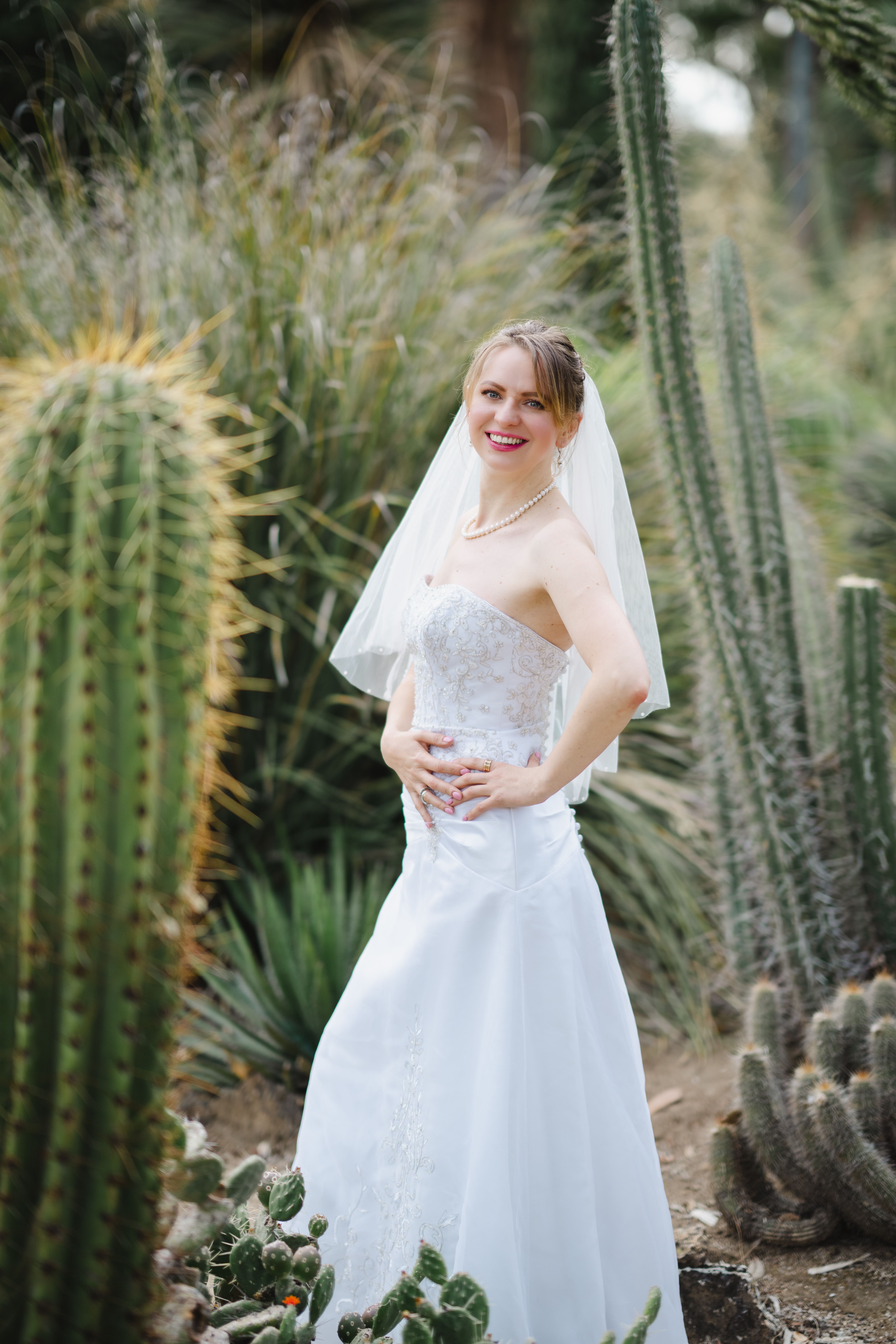 A Bride Posing Near a Cactus · Free Stock Photo