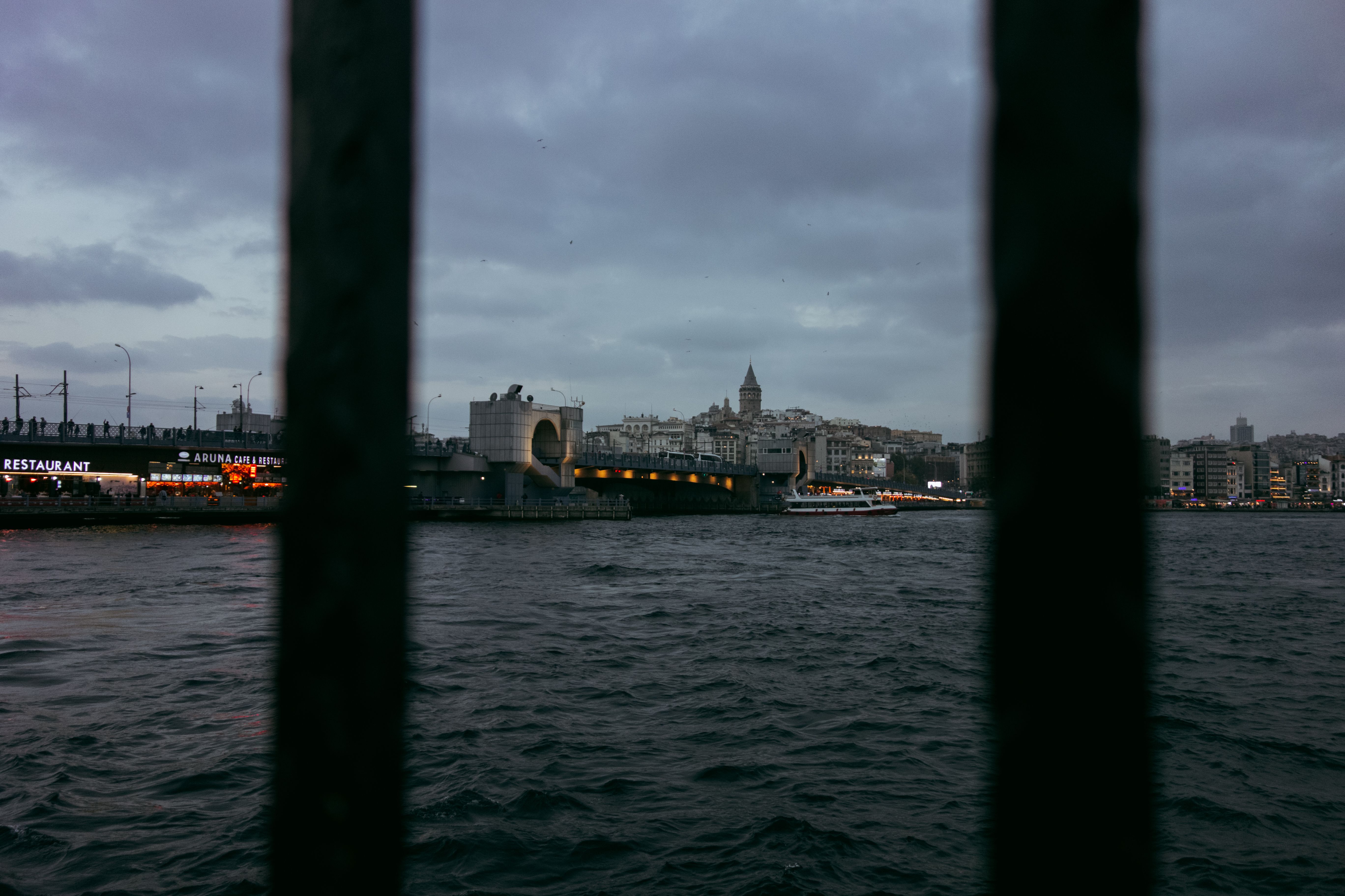 View through Gates at Water and Bridge on Sunset · Free Stock Photo