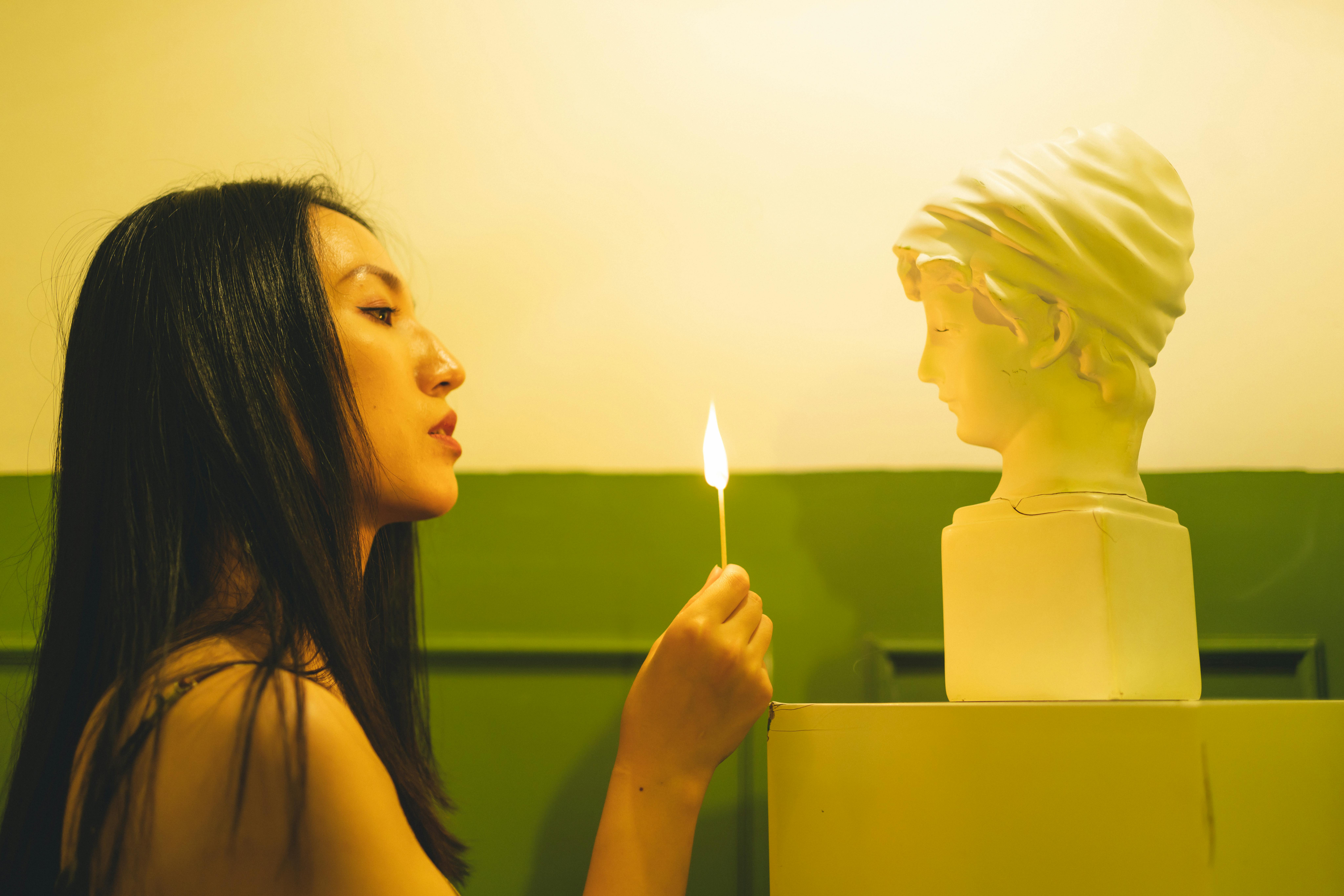 A Woman Holding a Lighted Match · Free Stock Photo
