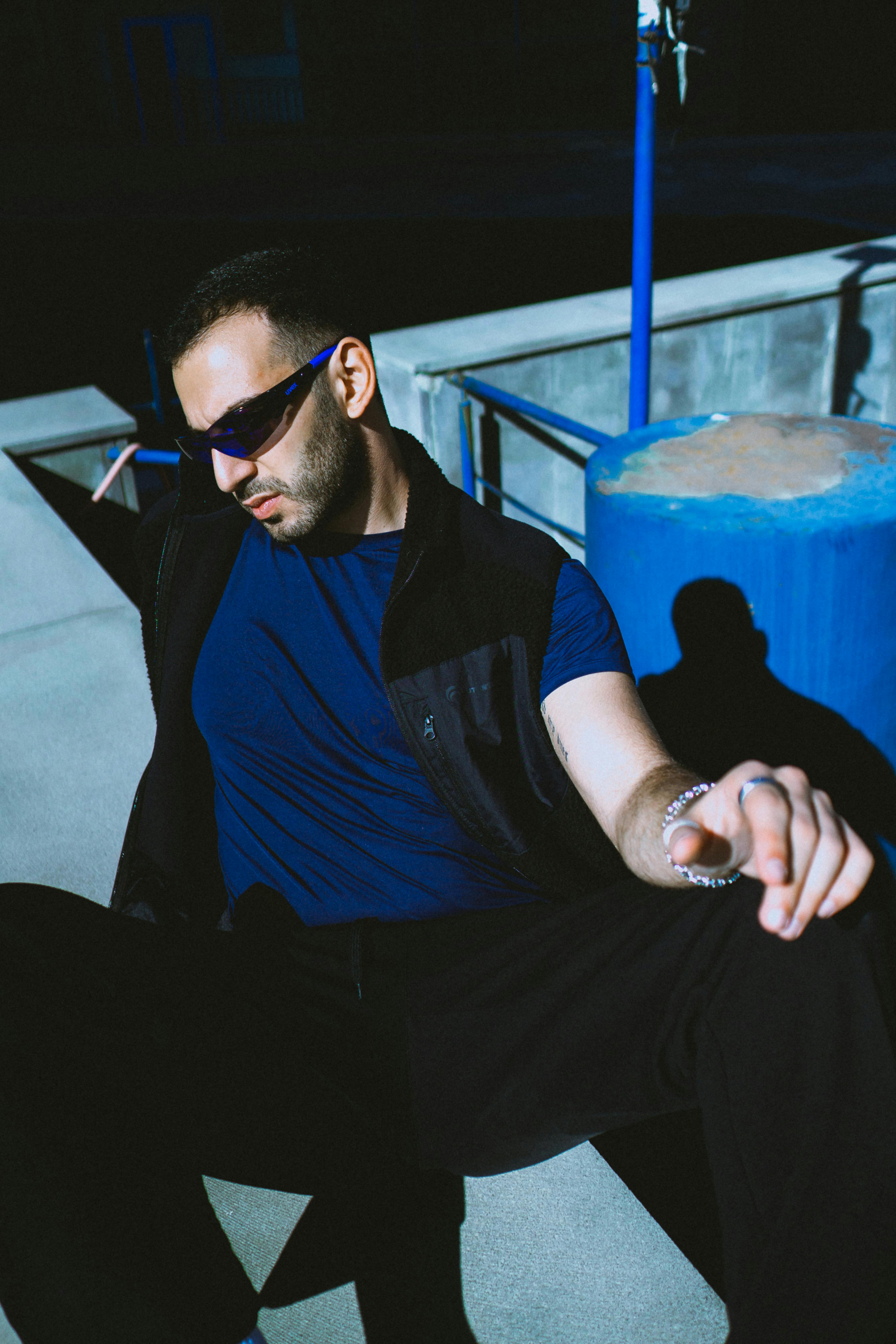 A Man in in Blue Shirt and Black Pants Standing Near Steel Rolling ...