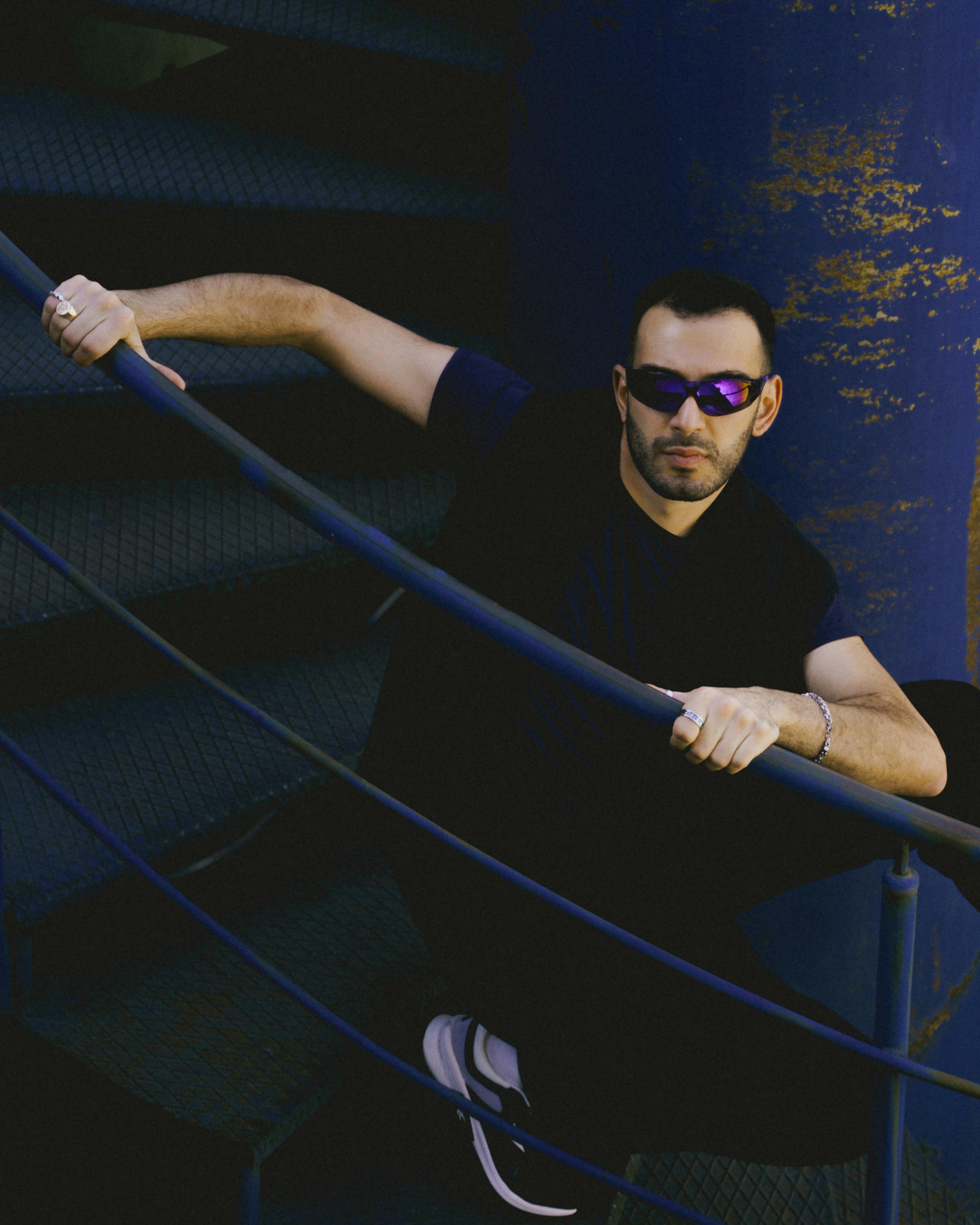 Man Crouching on Blue Stairs · Free Stock Photo
