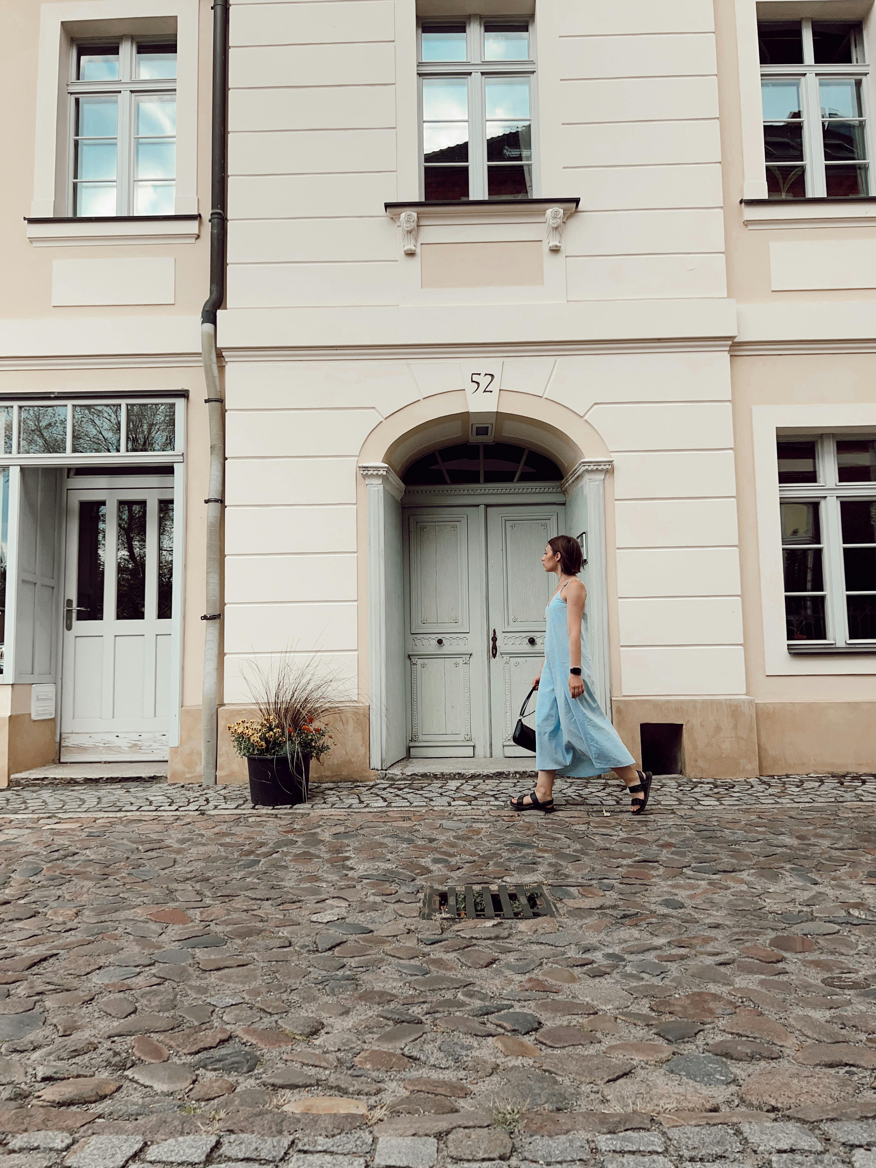 Woman Wearing a Pastel Blue Dress Walking by a Building Entrance · Free ...