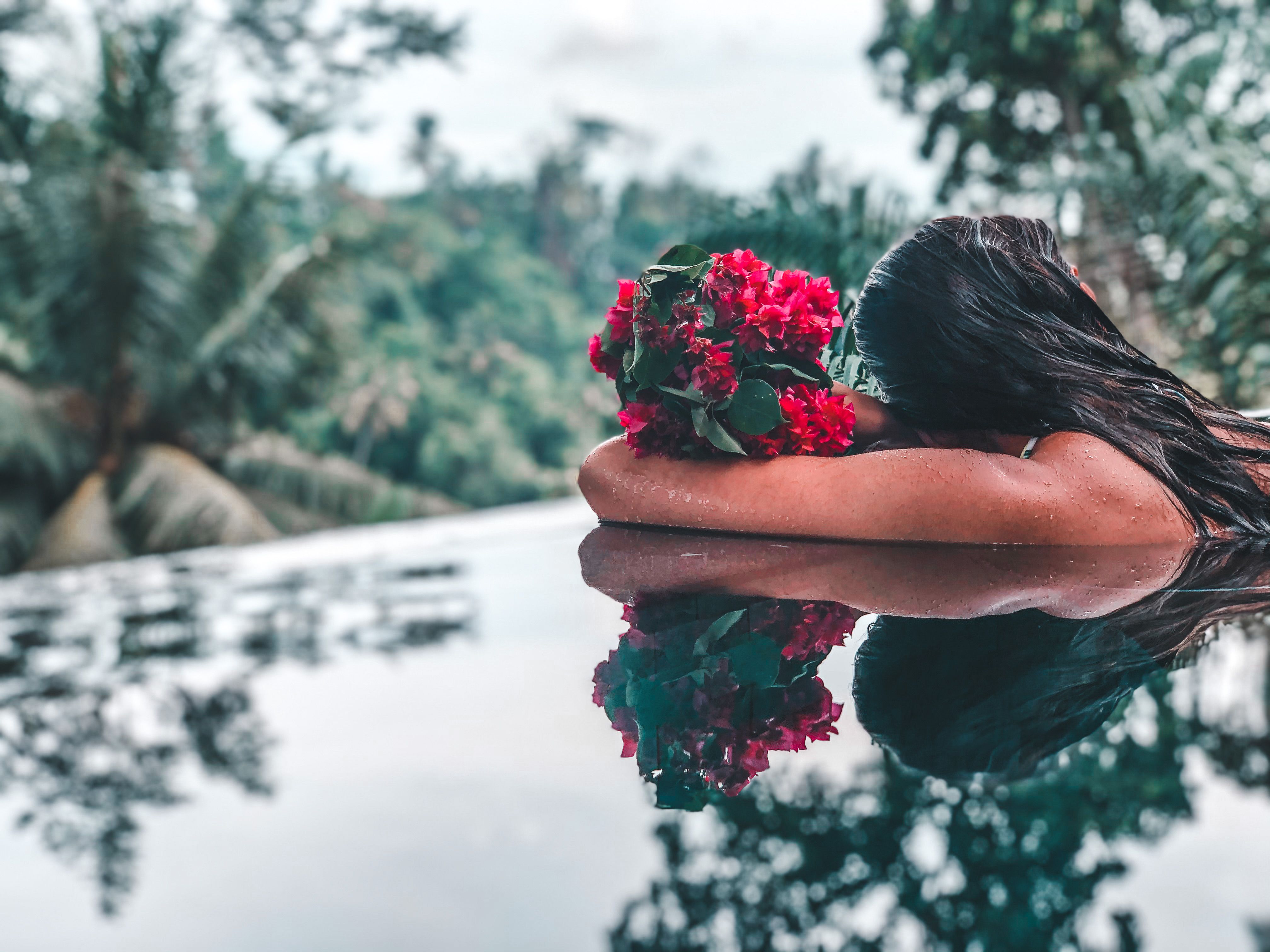 Woman on Body of Water Holding Bouquet of Flowers · Free Stock Photo